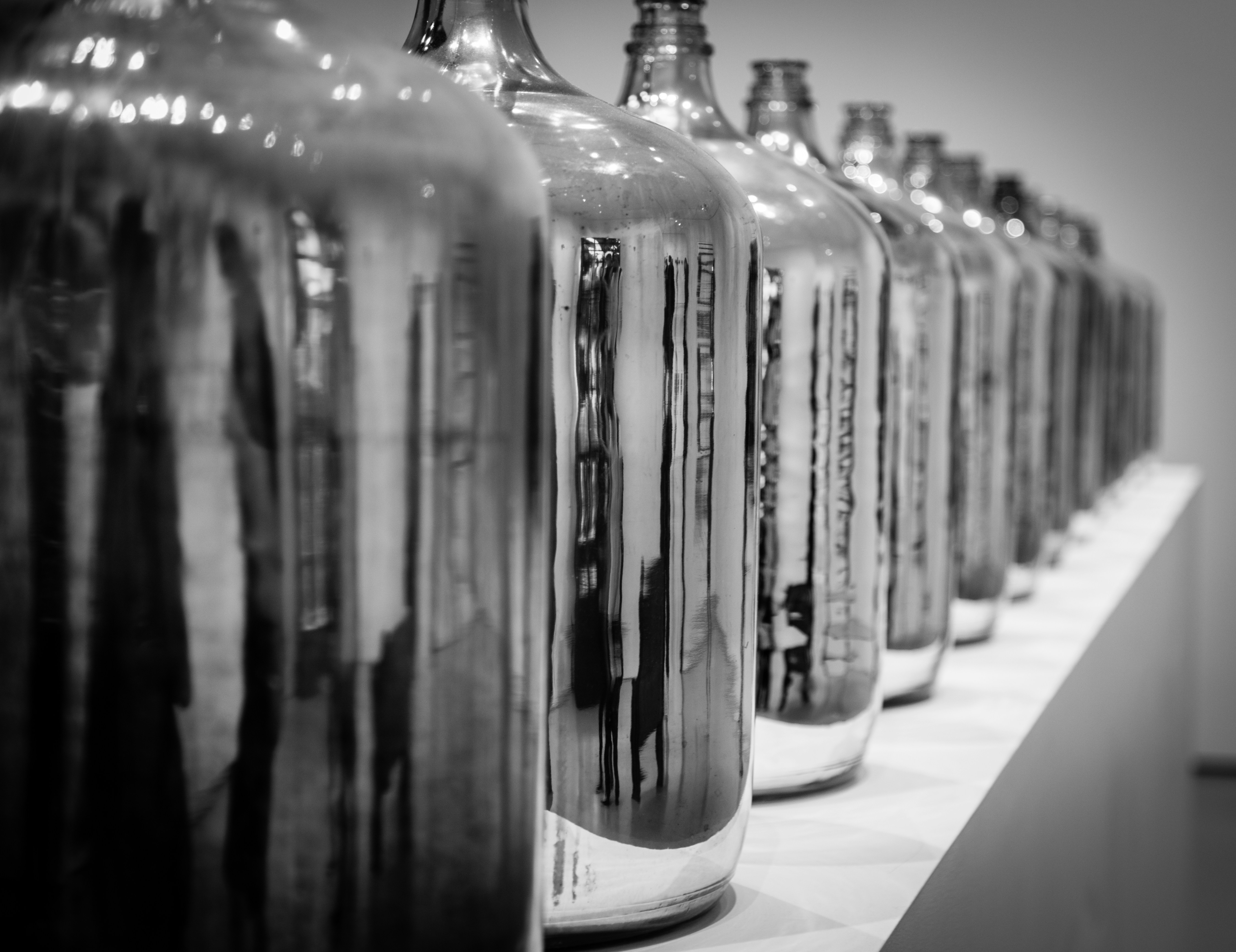 A row of glass bottles sitting on top of a counter photo – Free Bottle ...