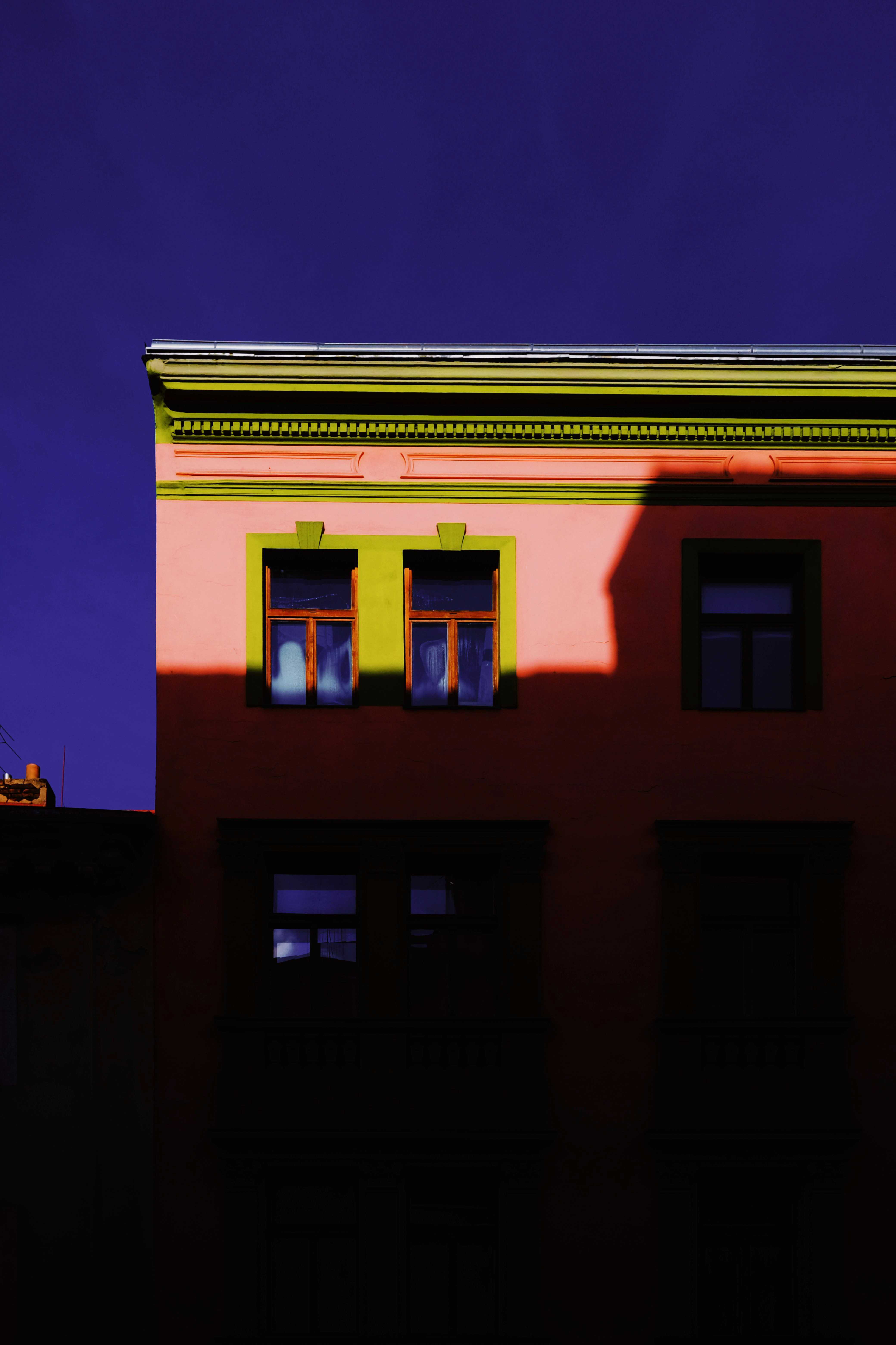 Cobalt Sky, Lime-Windows: A Coral Facade Cast in Shadow