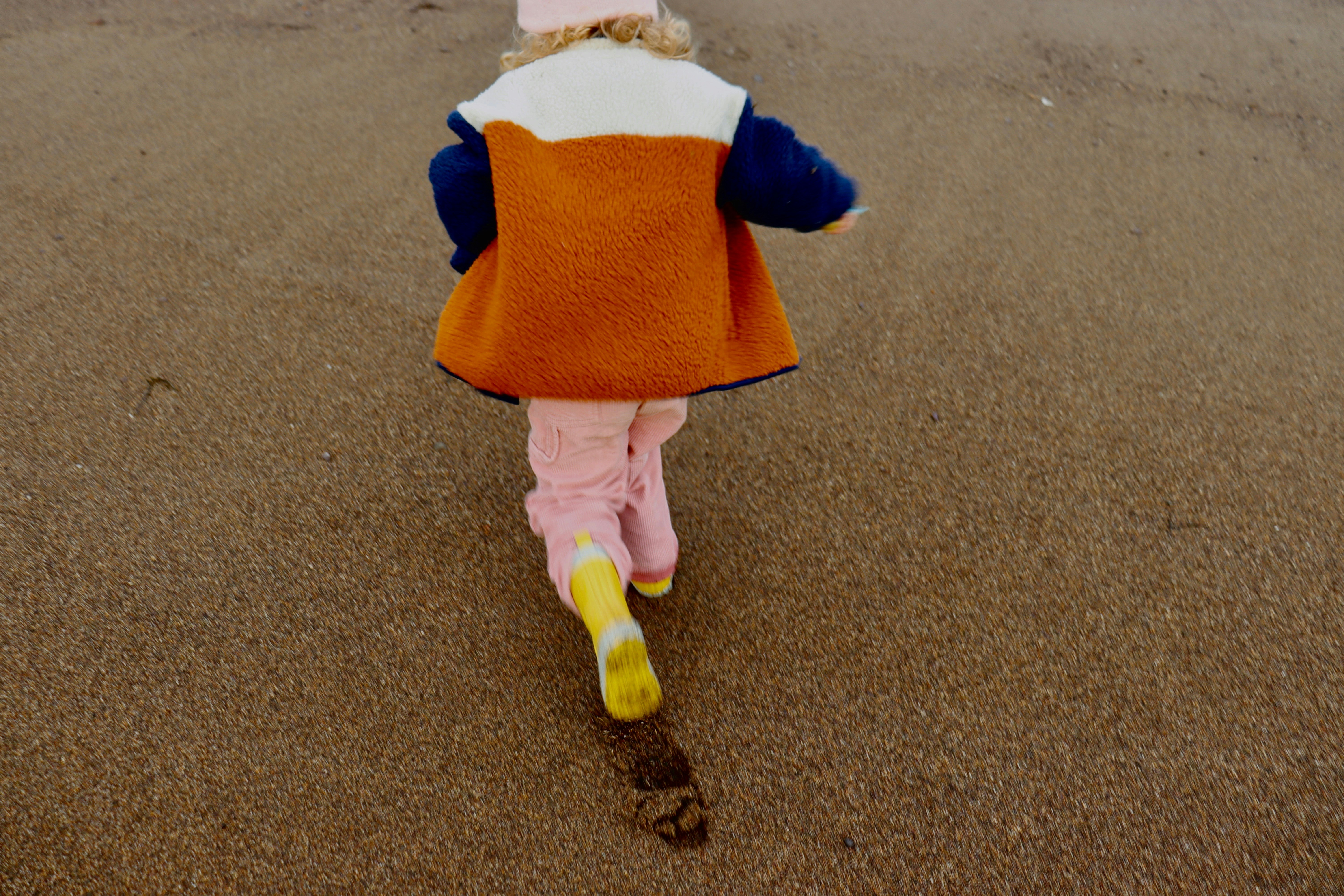 A little girl walking across a sandy beach photo – Free Beach Image on ...