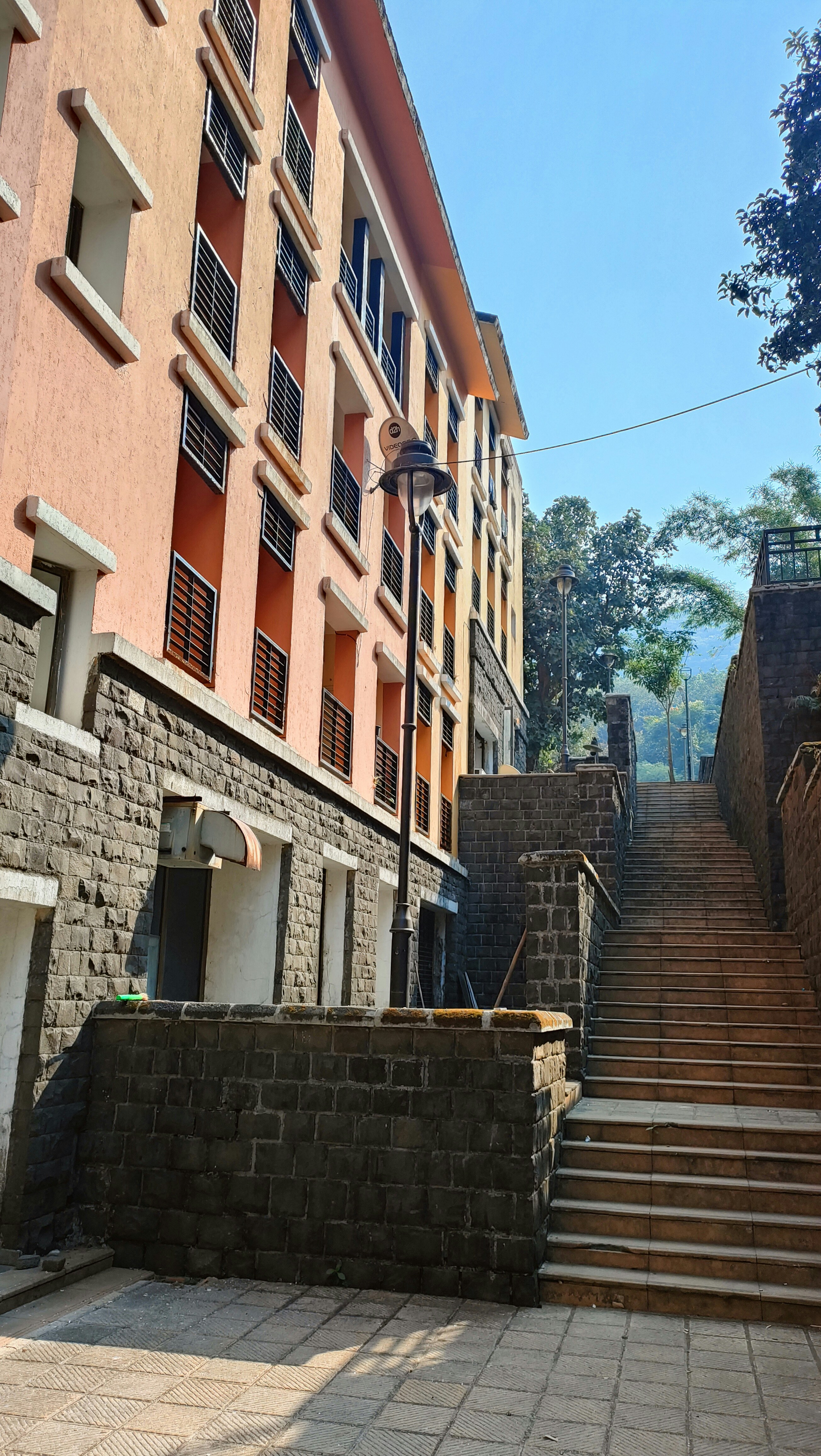 Long stairway with colourful buildings at the side and blue sky on a foggy winter