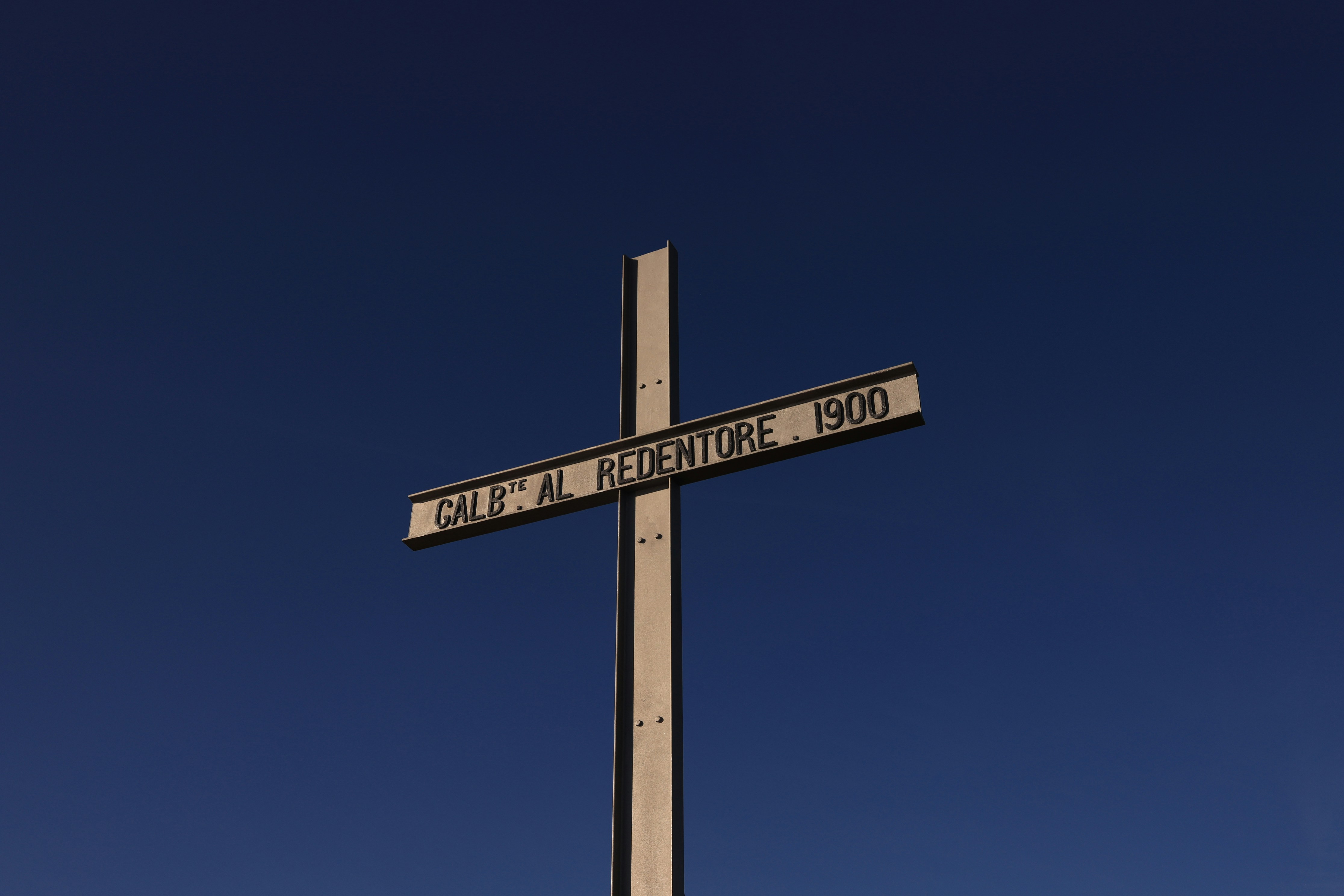 Cross-shaped street sign reading 'Sleepy Zhao' atop a metal pole against a clear blue sky.