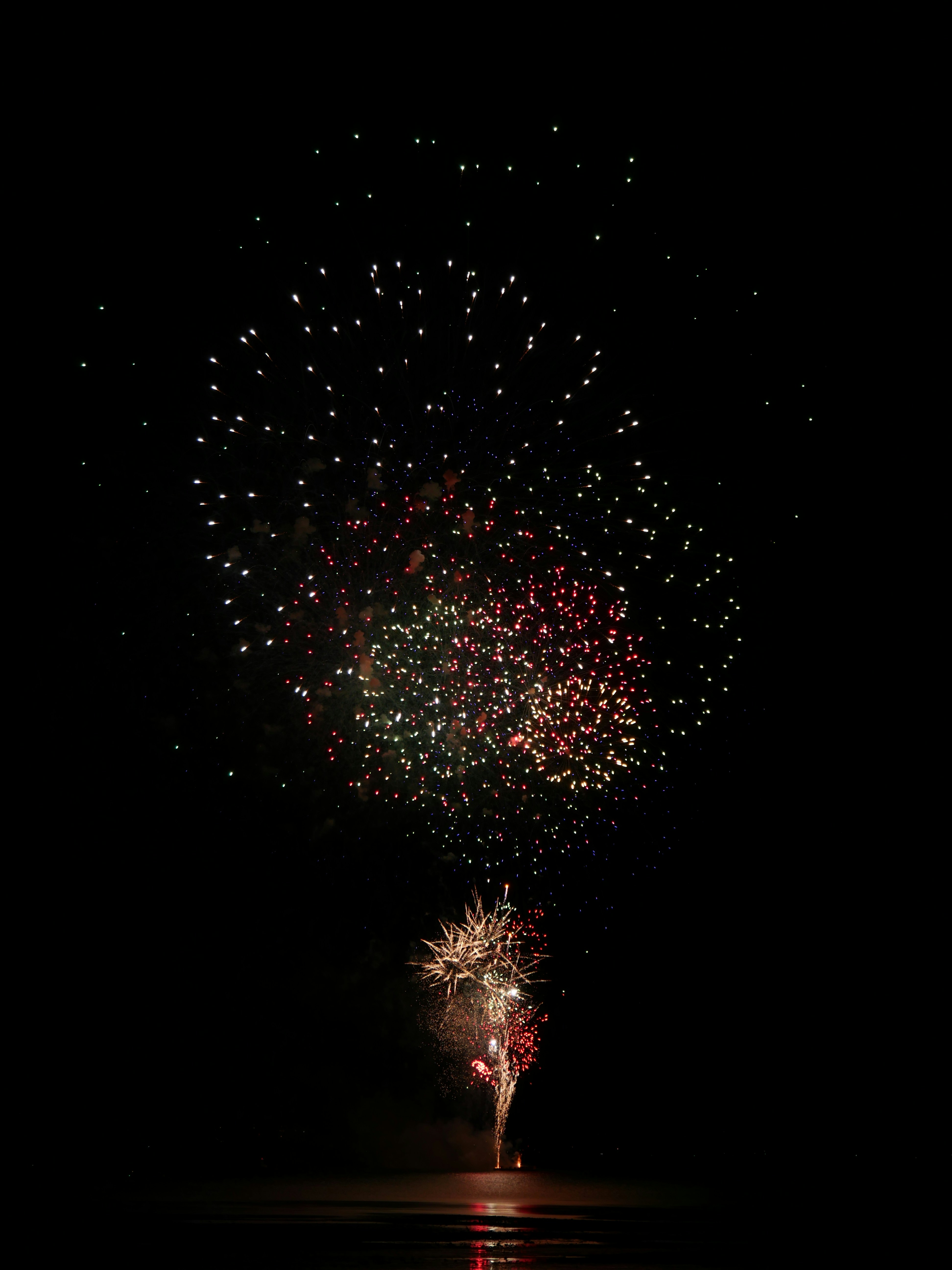Night Sky Ignites: Firework Bouquet Over Quiet Waters