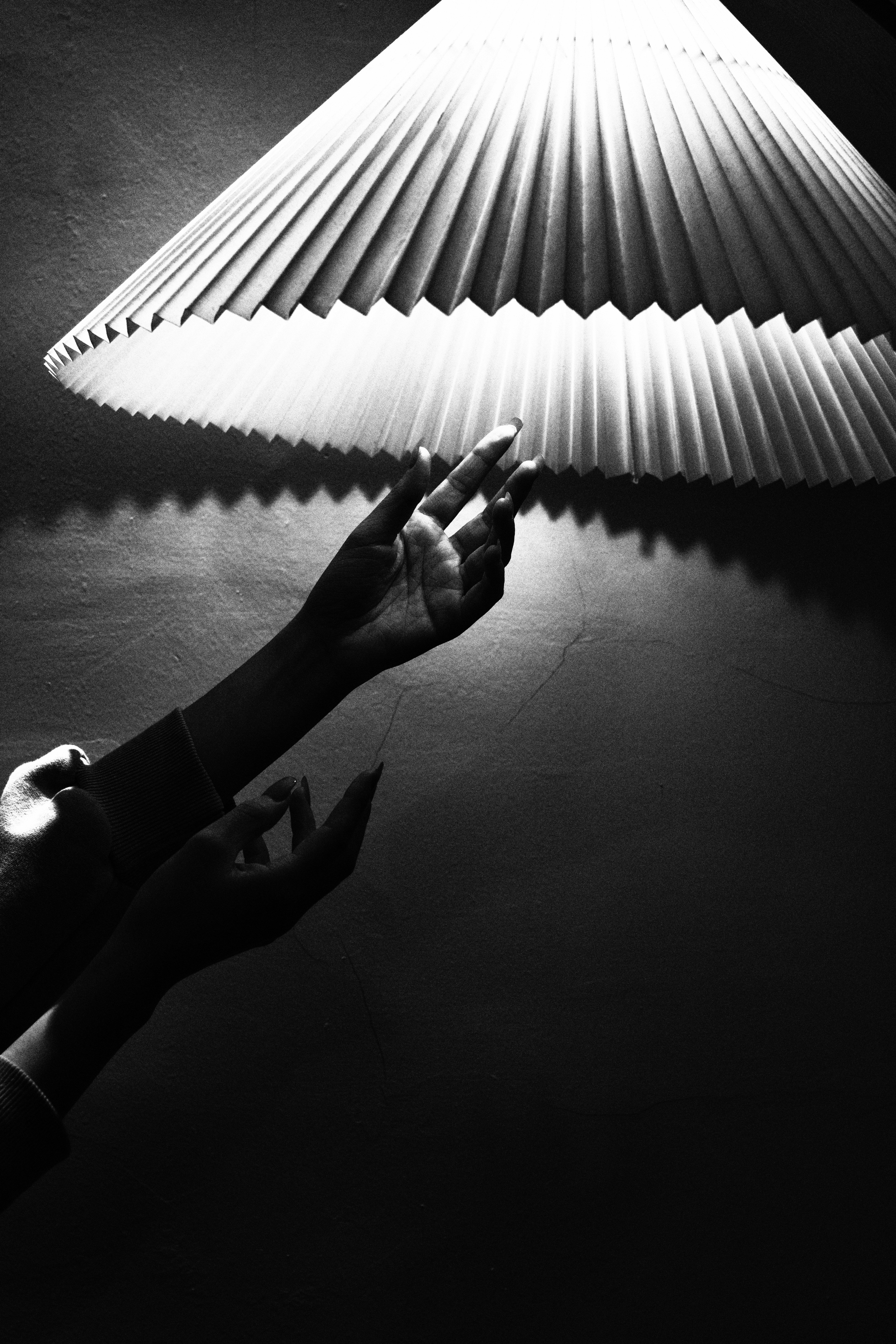 Hands Meet the Lamp: A Quiet Moment of Shadow and Light