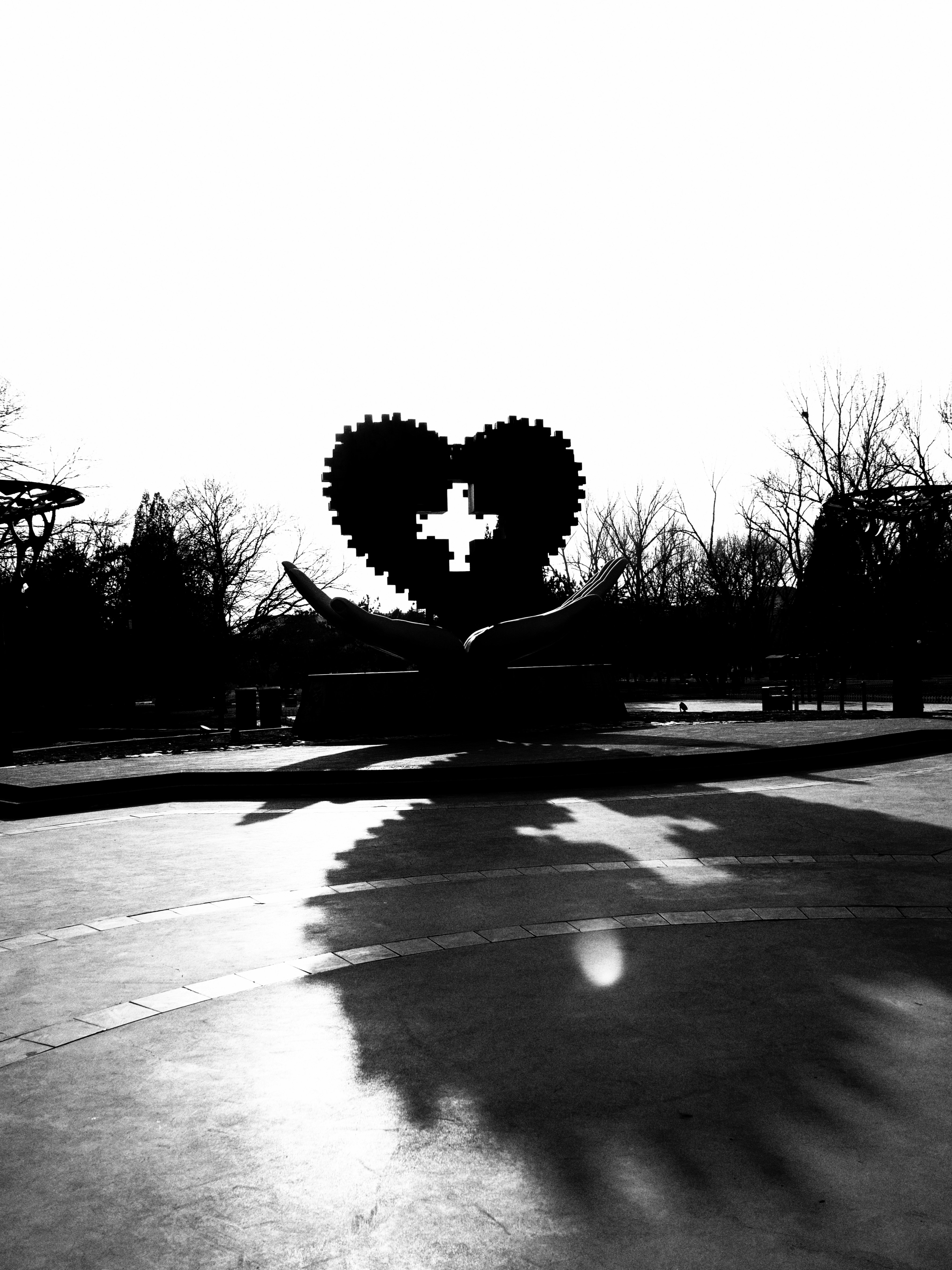 Pixel Heart Monument: Stark Silhouette in a Sun-bleached Park