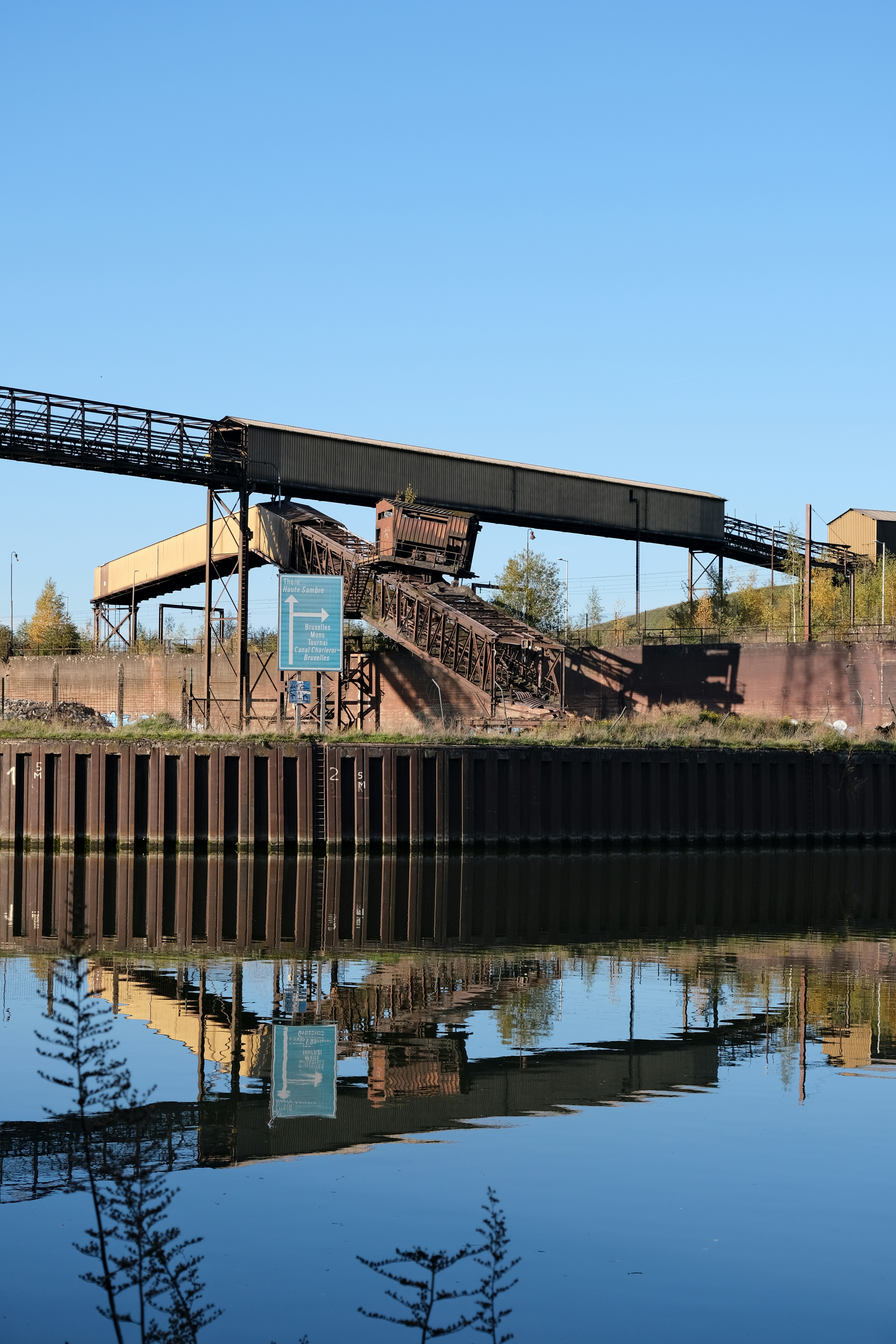 Rusted Conveyor Framework Over a Quiet Riverside