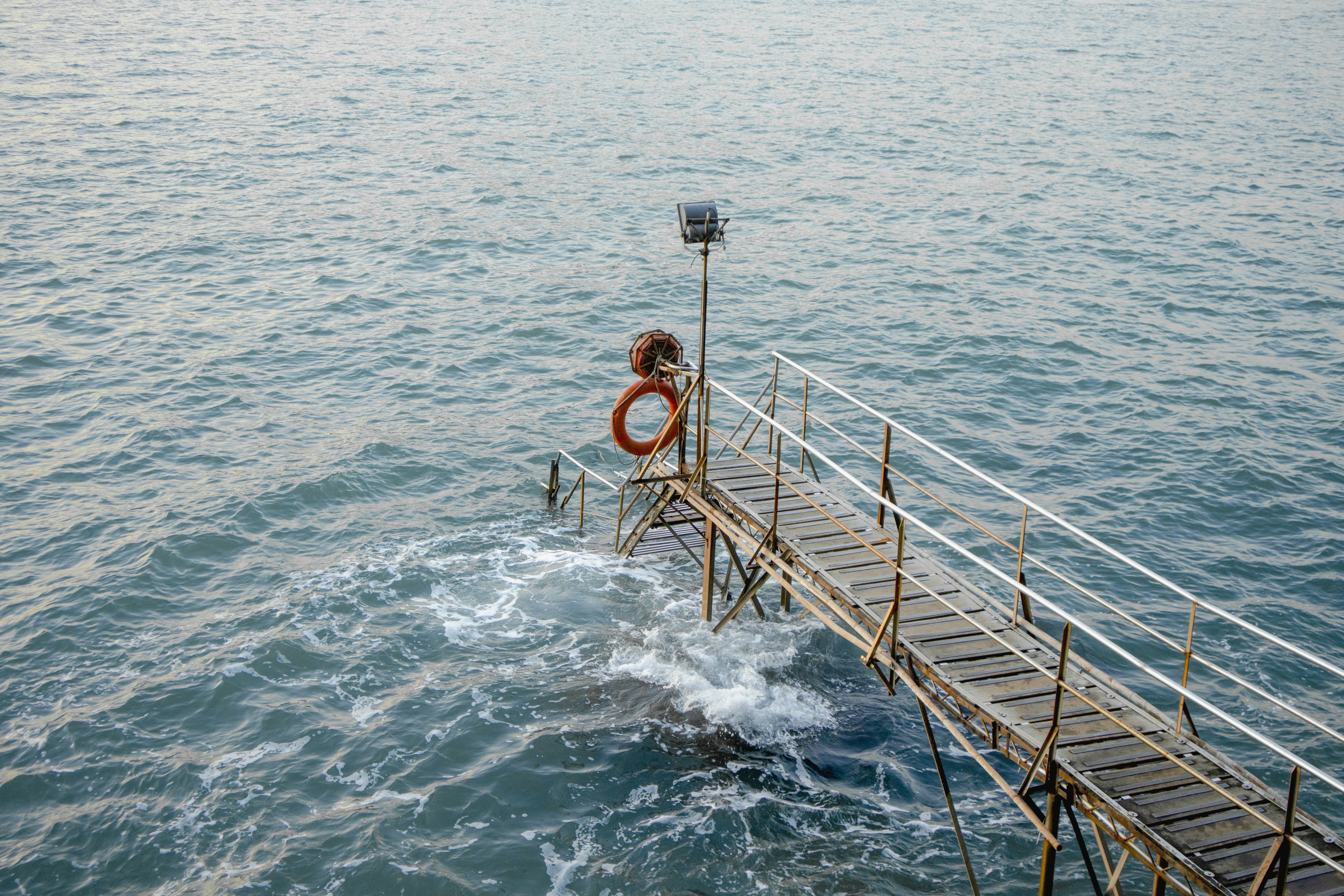 A dock with a life preserver and a life preserver on it photo – Free ...