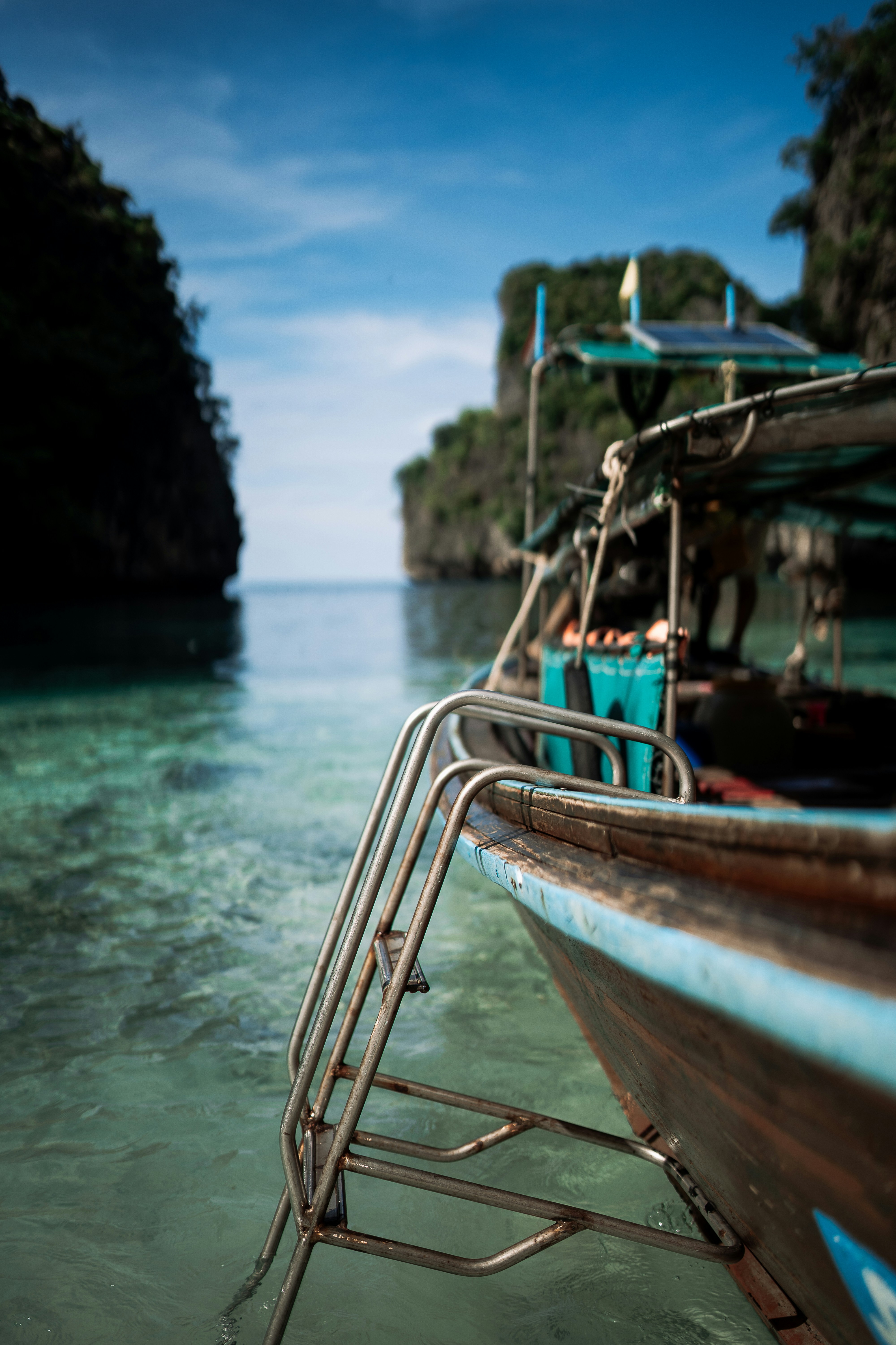 Riveted Bowlines Over Turquoise Water: Boat Framed by Cliffside Silence