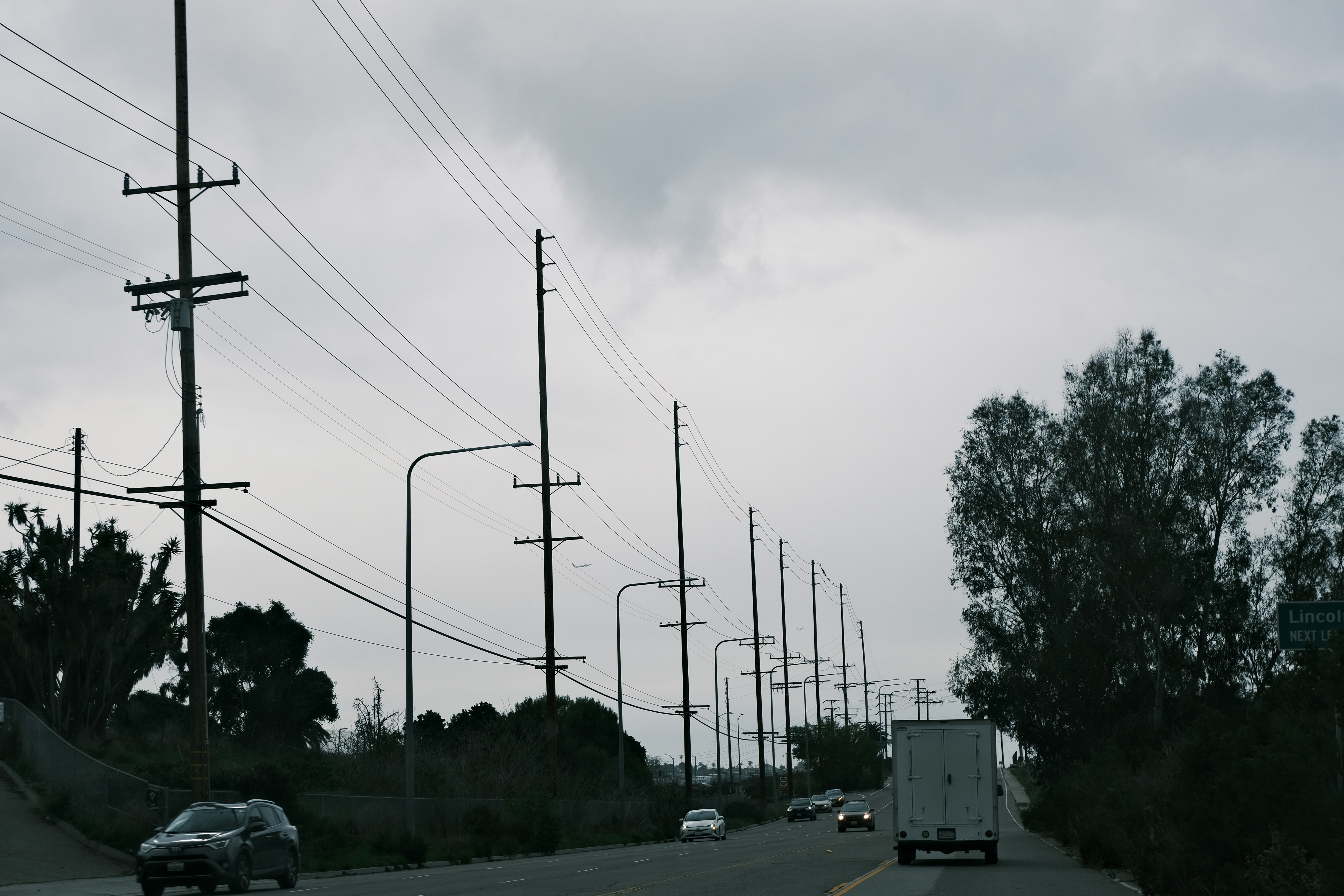 a truck driving down a street next to power lines