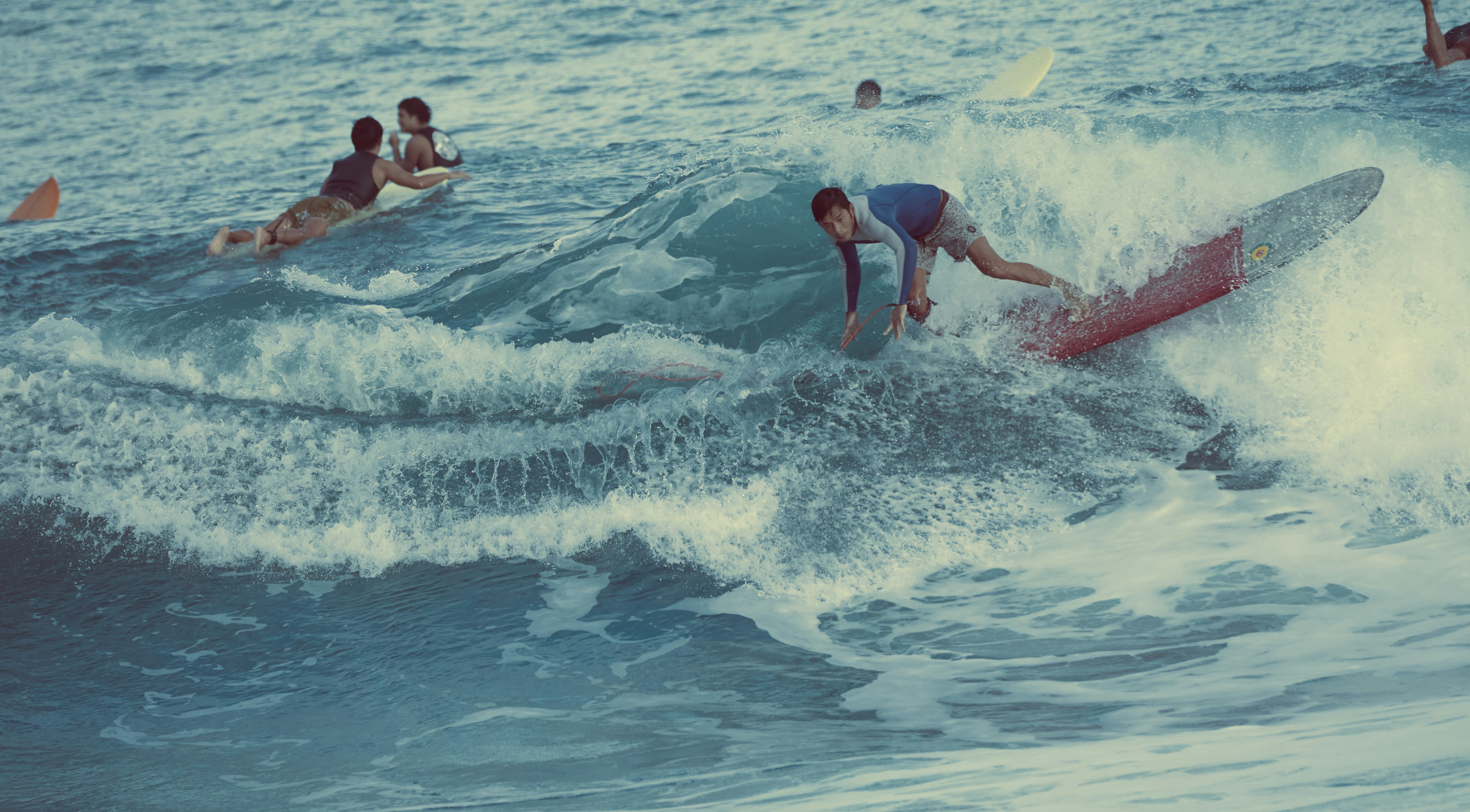 A group of people riding waves on top of surfboards photo – Free Image ...