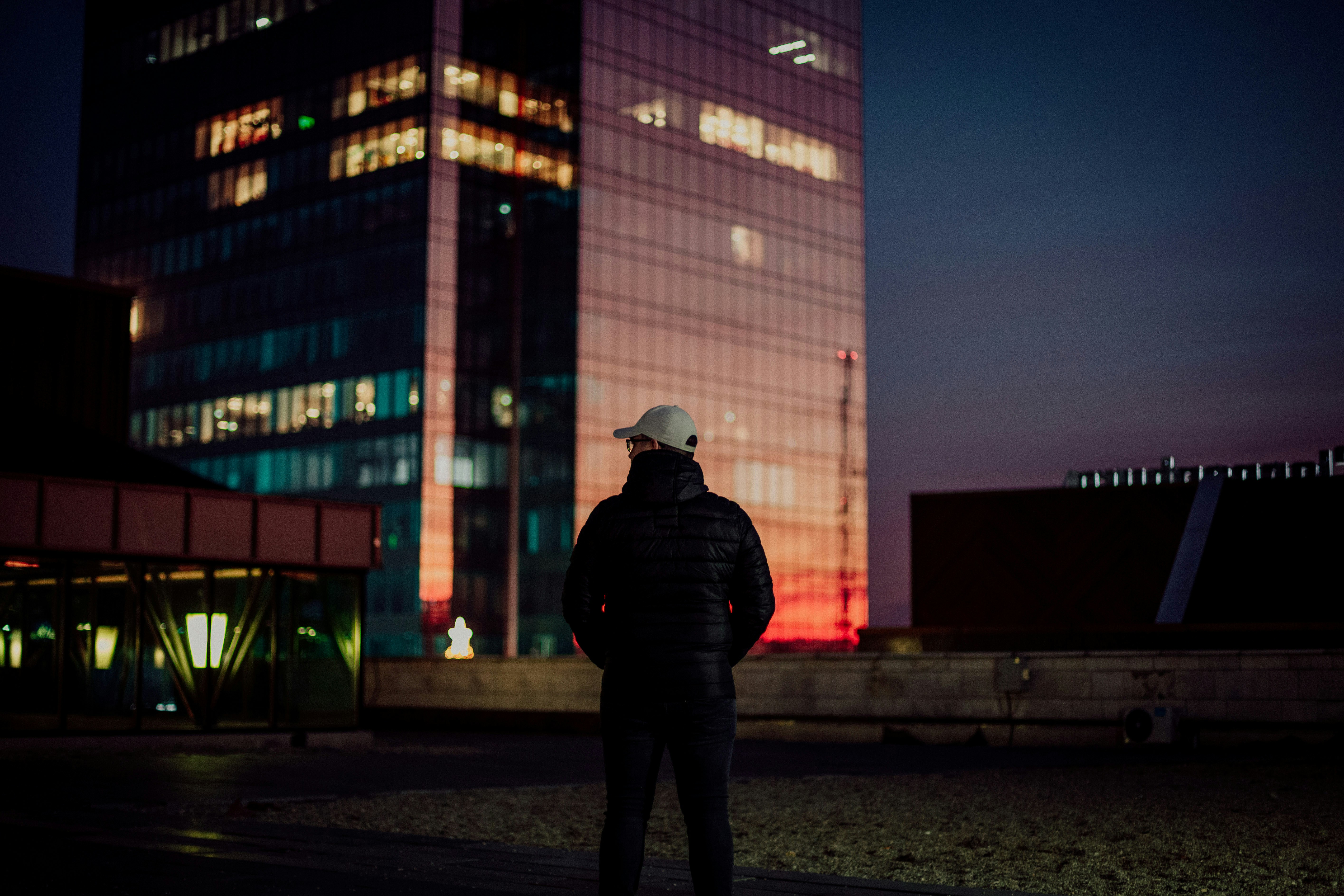 A man standing in front of a tall building photo – Free Wallpaper Image ...