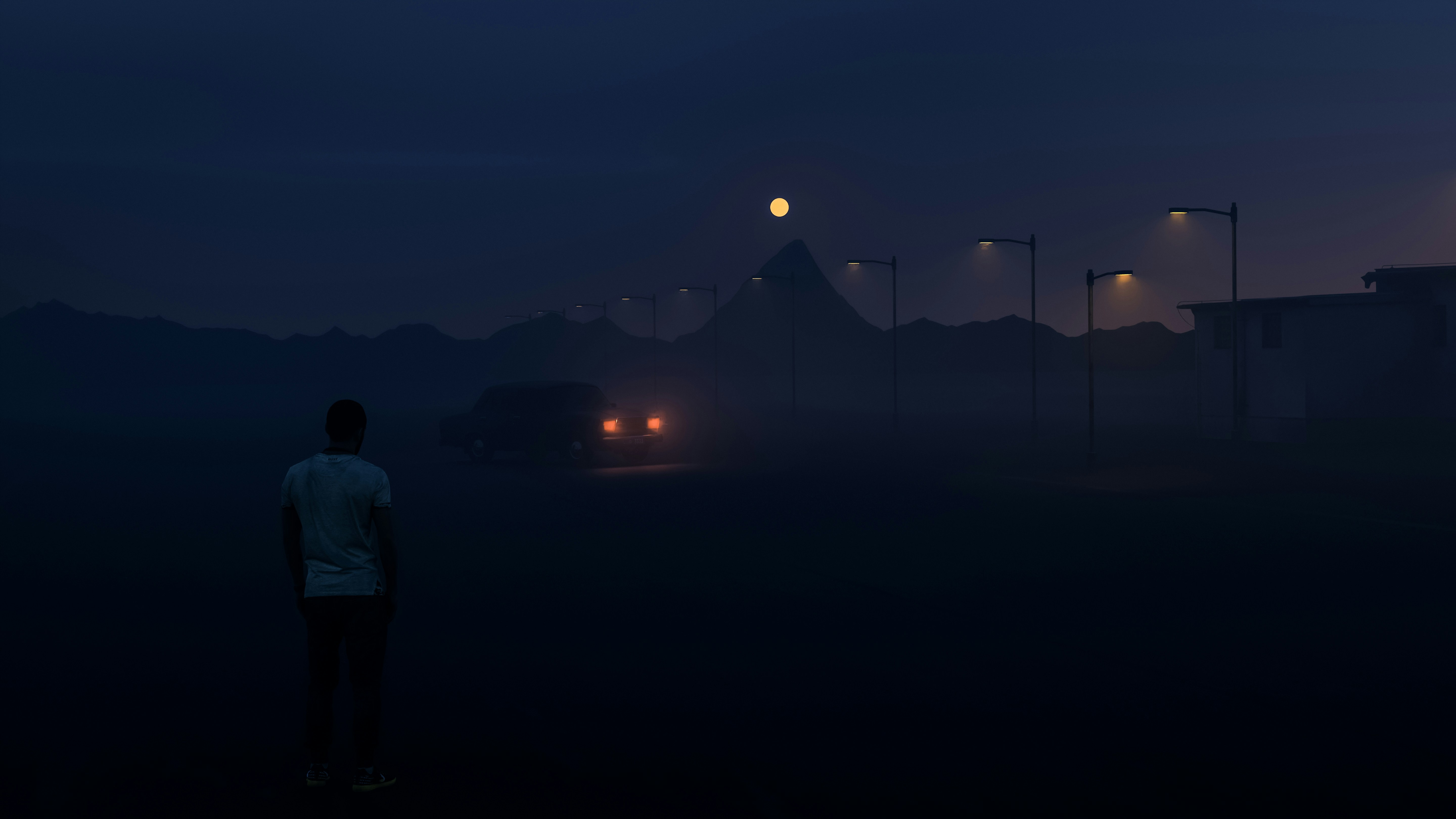 A man standing in the dark looking at the street lights photo – Free ...