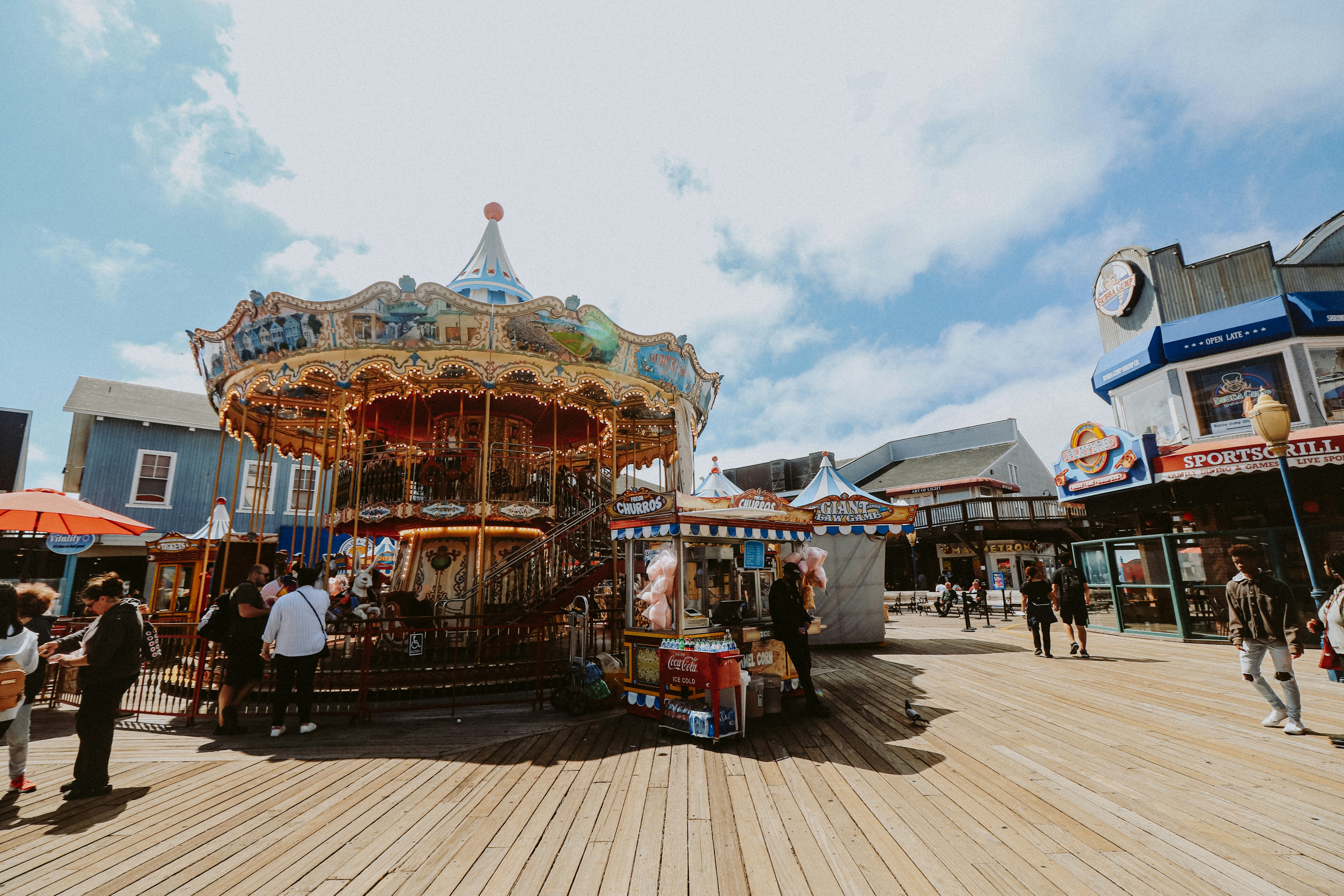 Pastel Carousel on a Sunlit Boardwalk Amid Shops and Sky