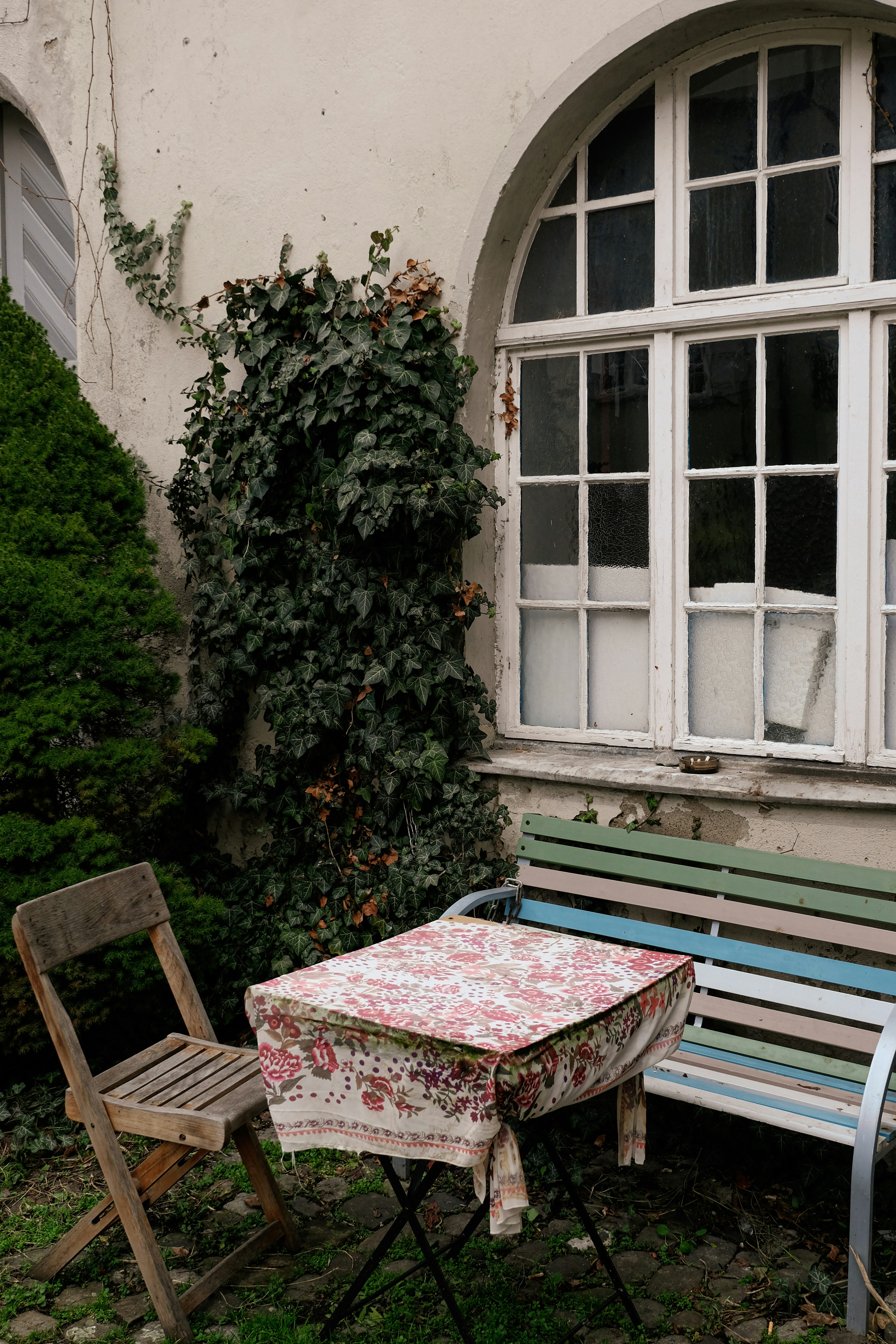Quiet Corner With Floral Tablecloth and Weathered Seating