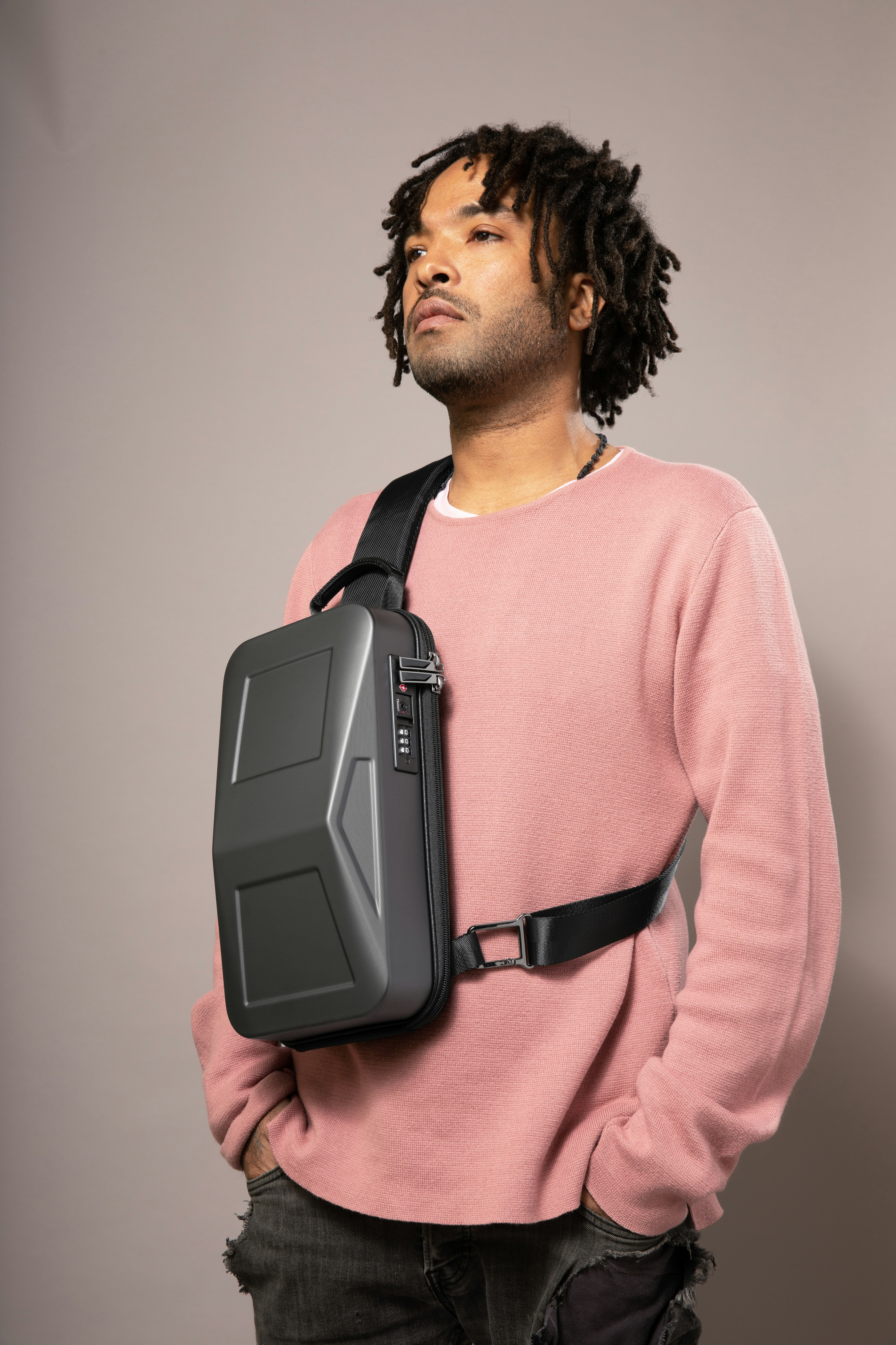 A man with dreadlocks holding a black bag photo – Free Backpack Image ...
