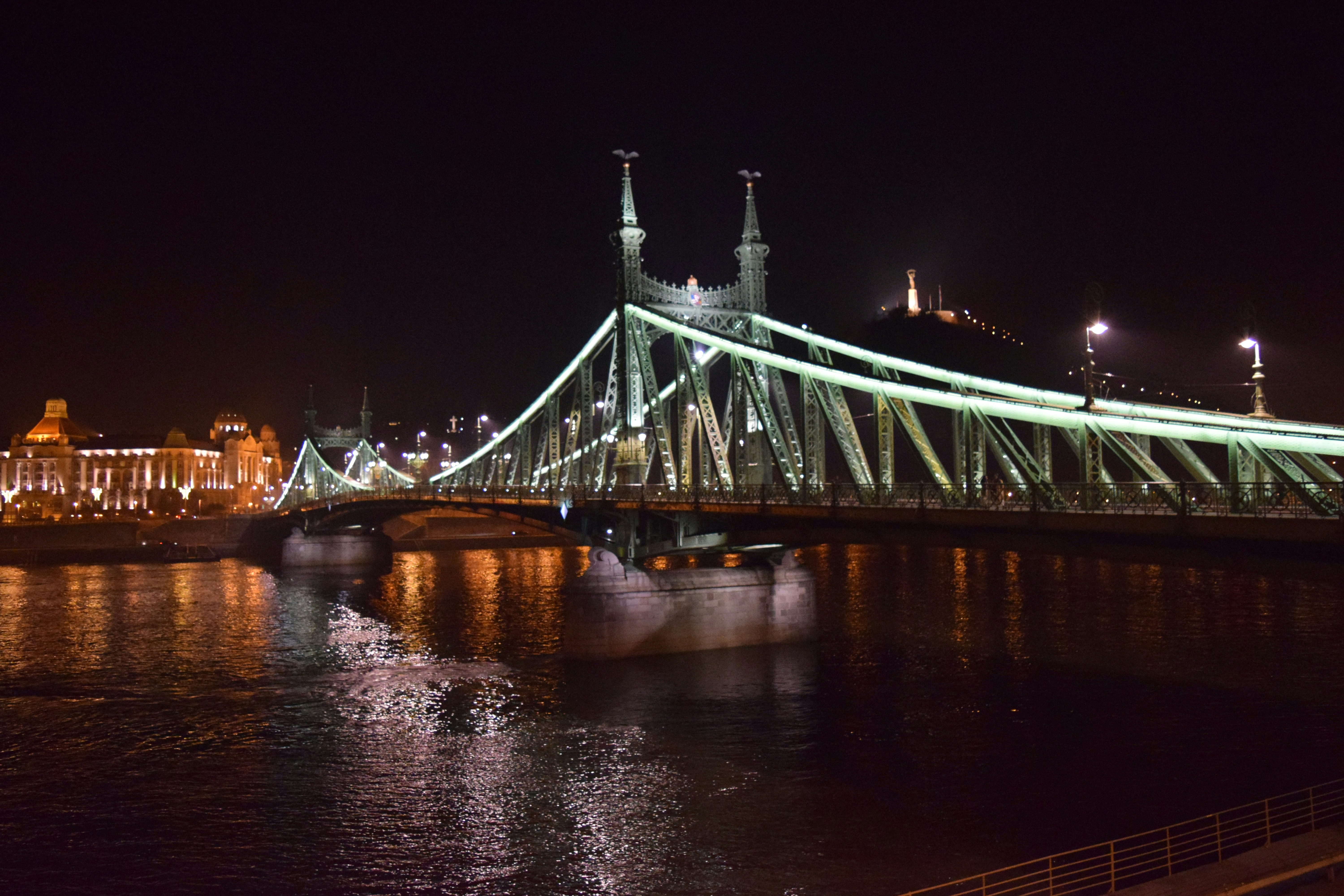 A bridge lit up at night over a body of water photo – Free Wallpaper 4k ...
