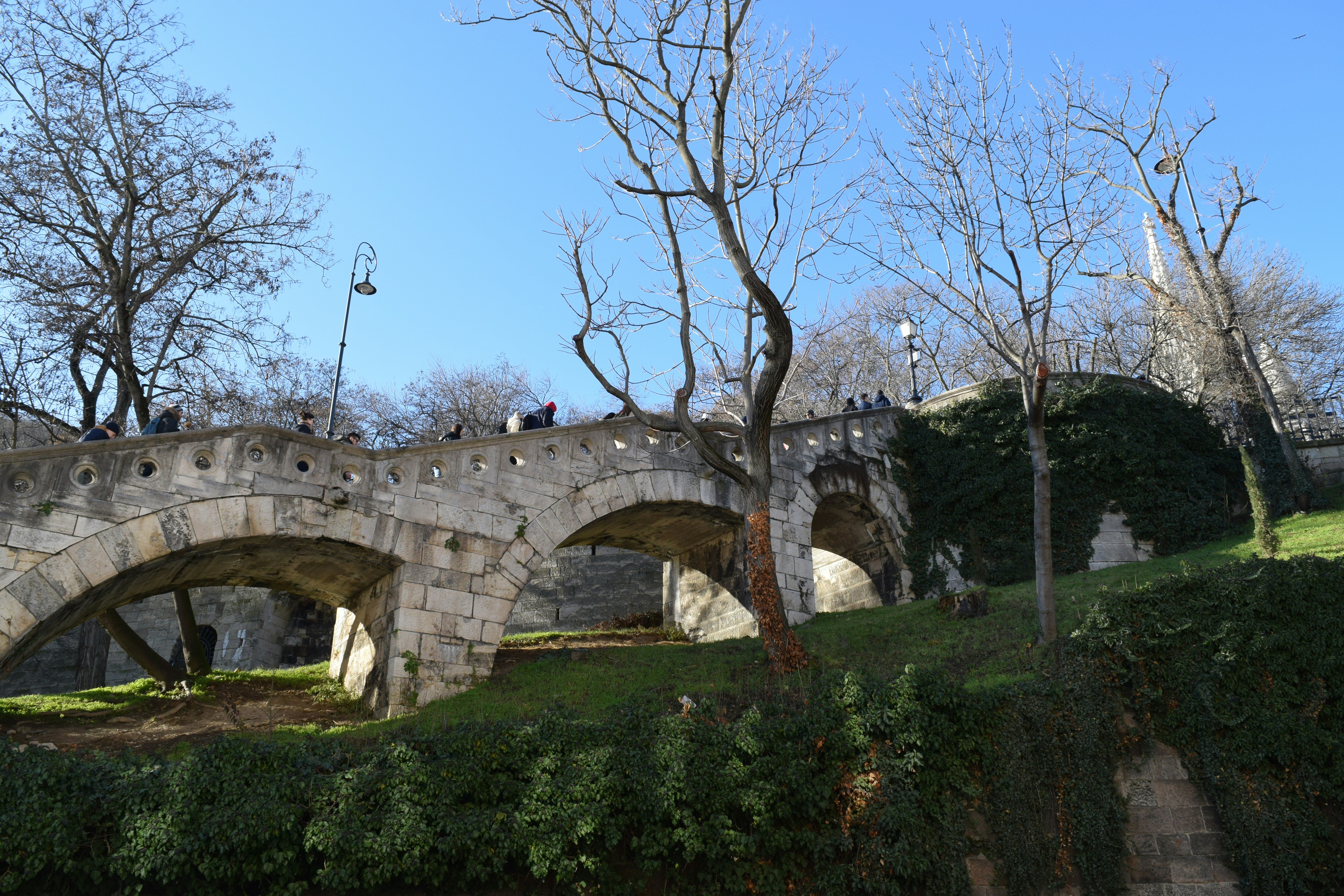 a stone bridge with people walking over it