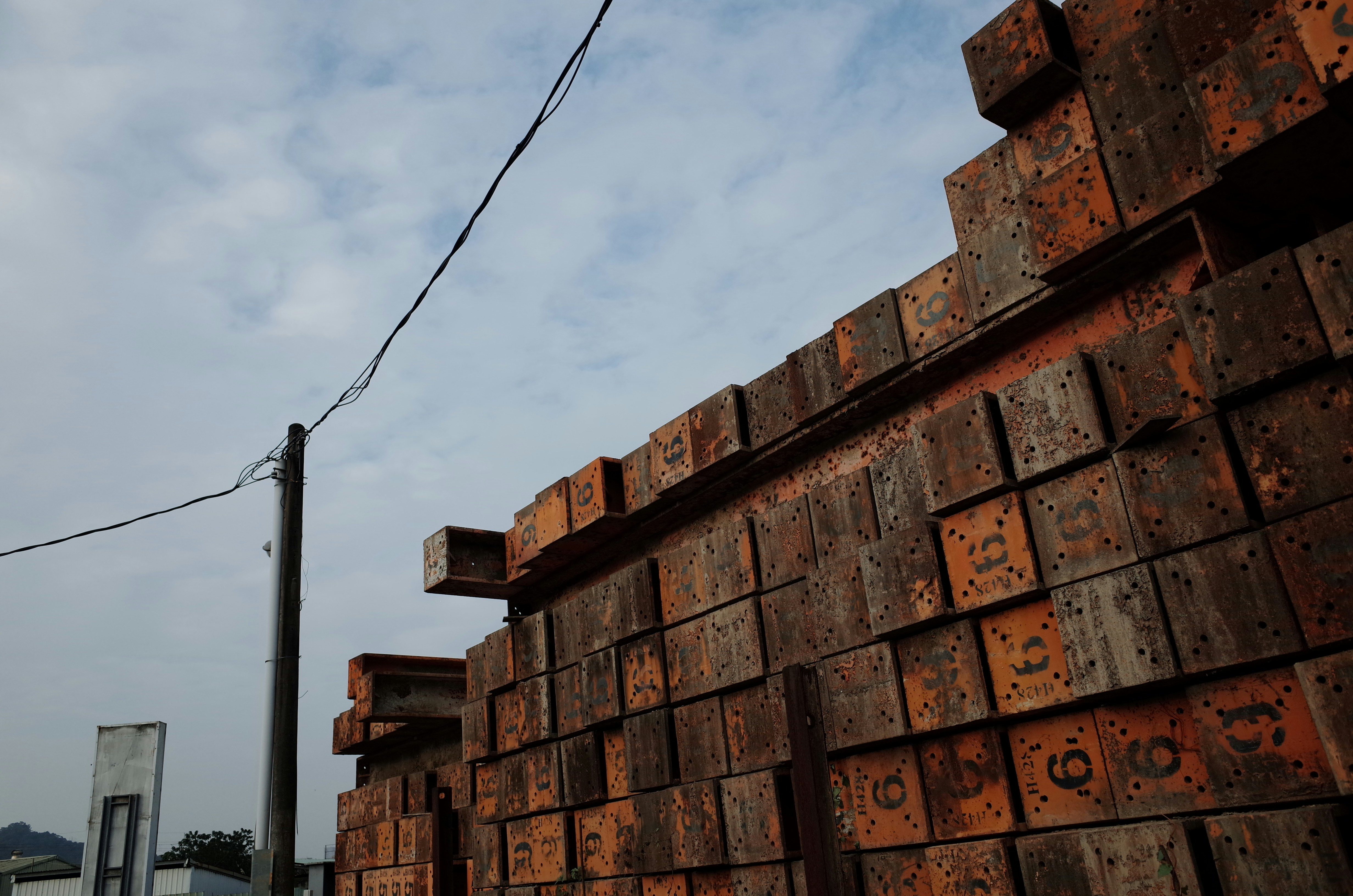 A large stack of metal boxes sitting next to a telephone pole photo ...