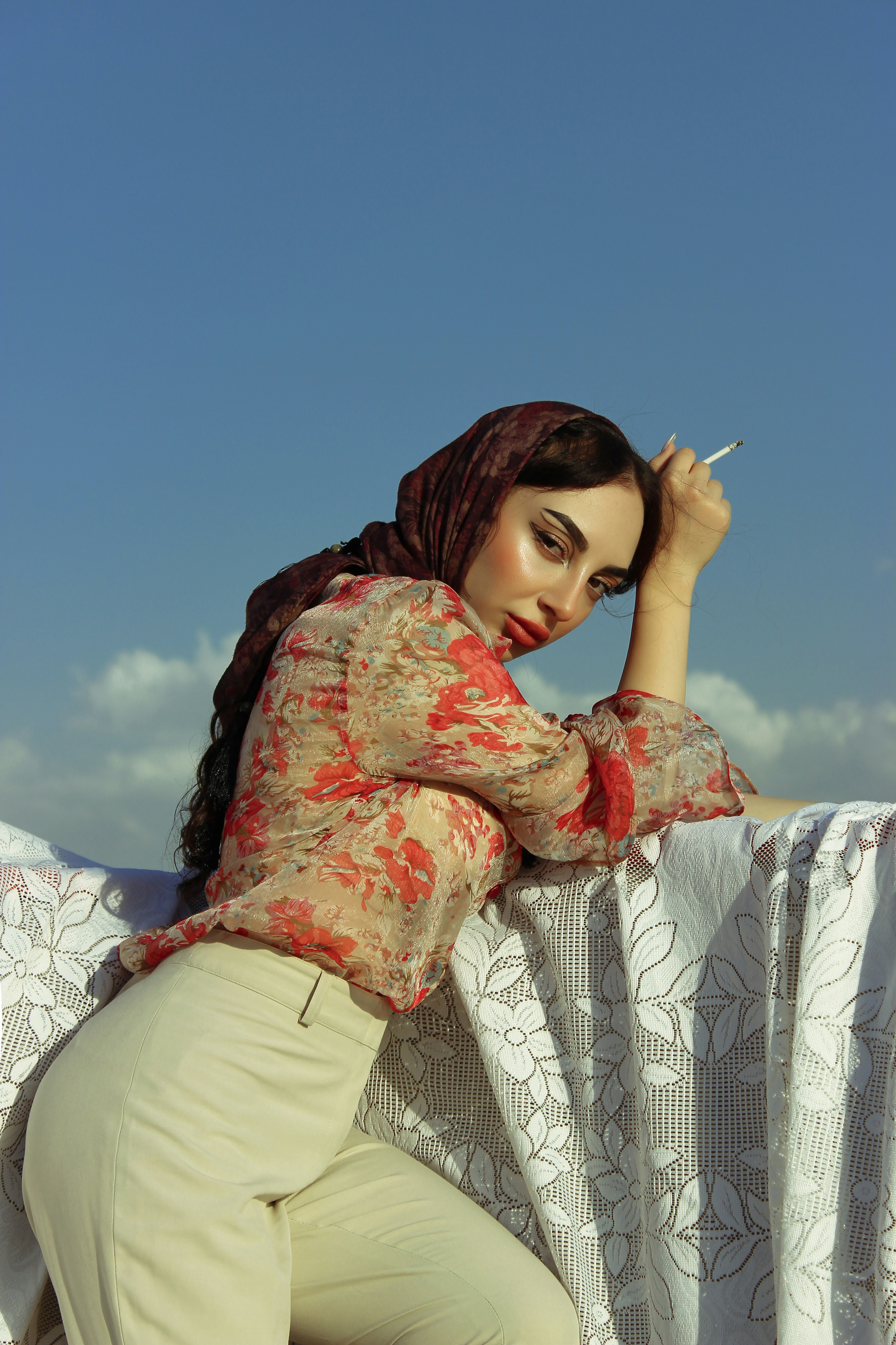 A woman sitting on a bed smoking a cigarette photo – Free Tabriz Image ...