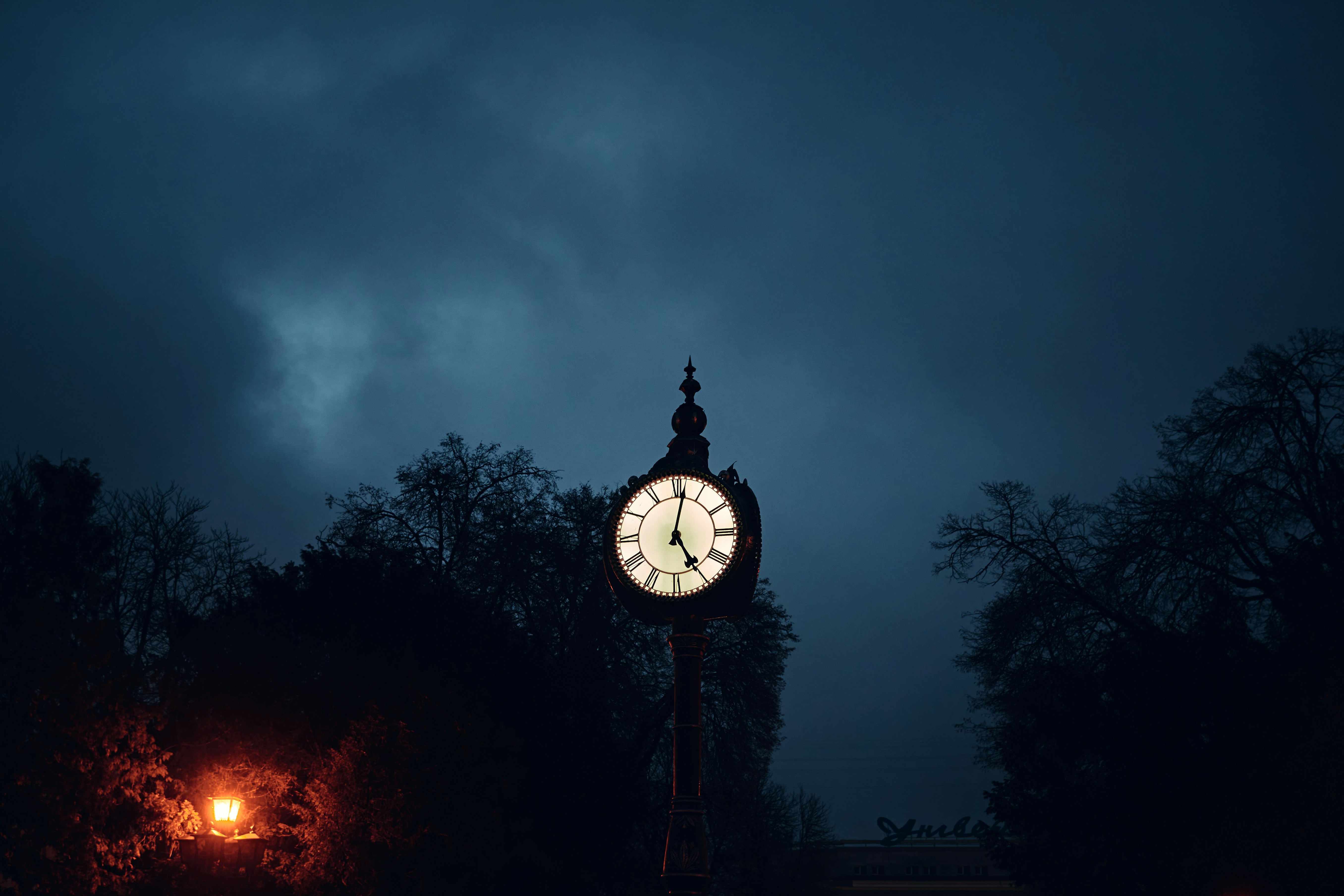 a clock on a pole in the middle of the night