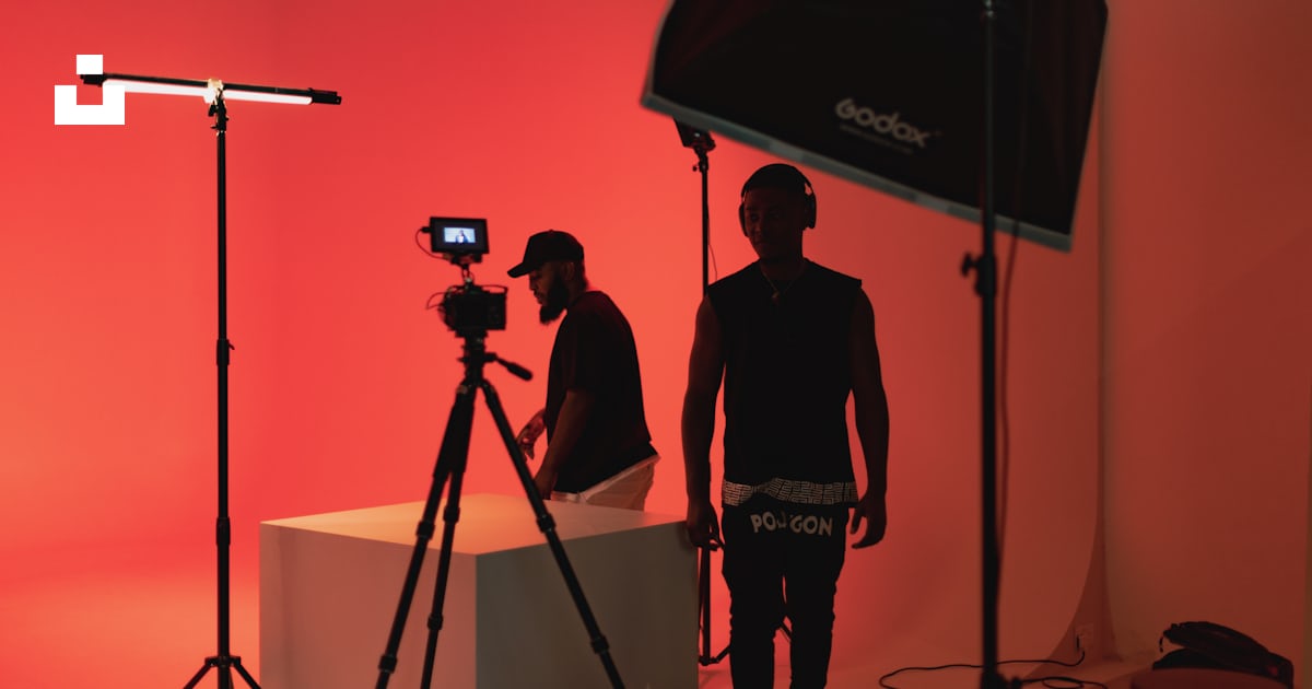 Un Homme Debout à Côté Dune Caméra Devant Un Mur Rouge Photo Photo