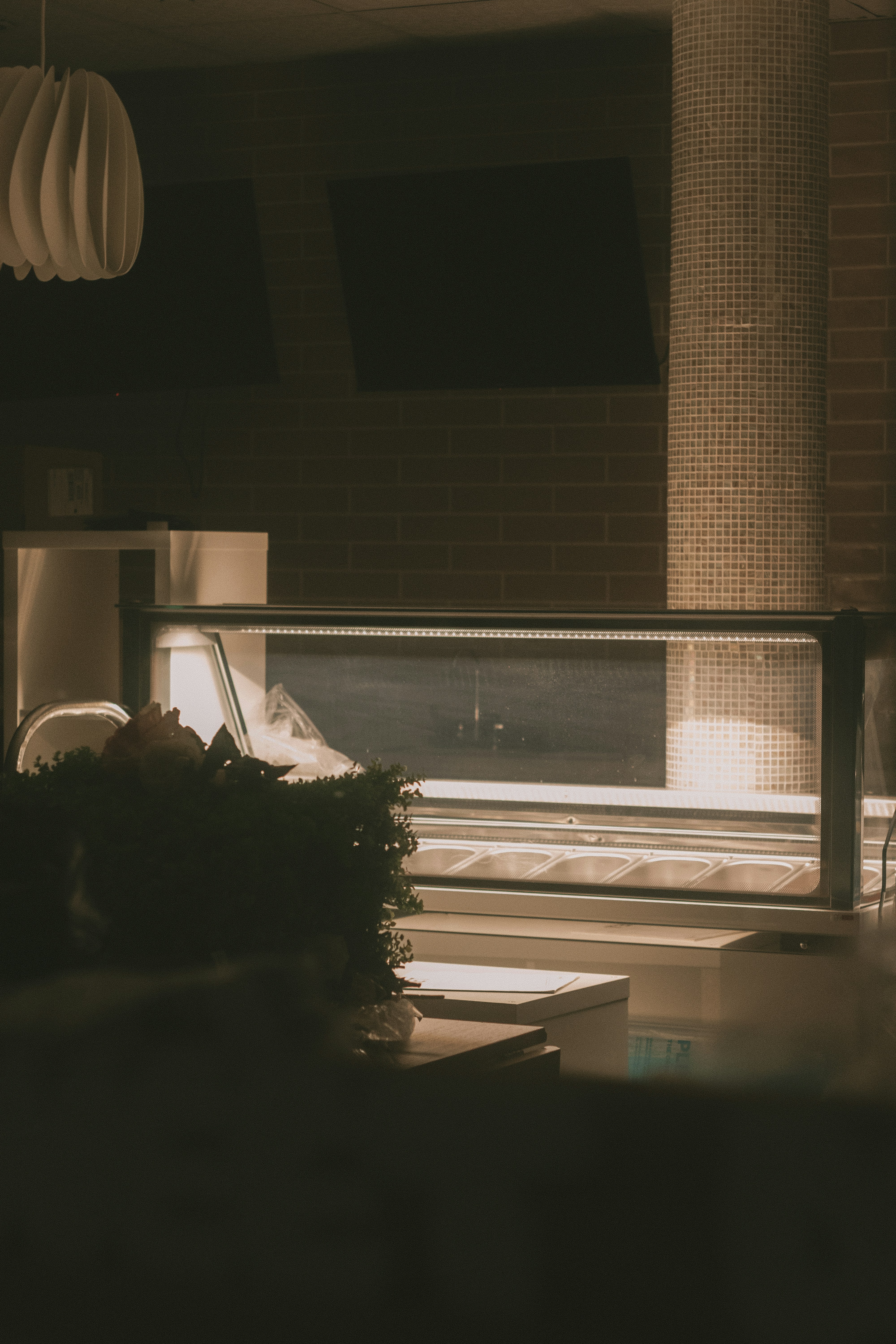 Dim Cafeteria Display Case Under Warm Neon