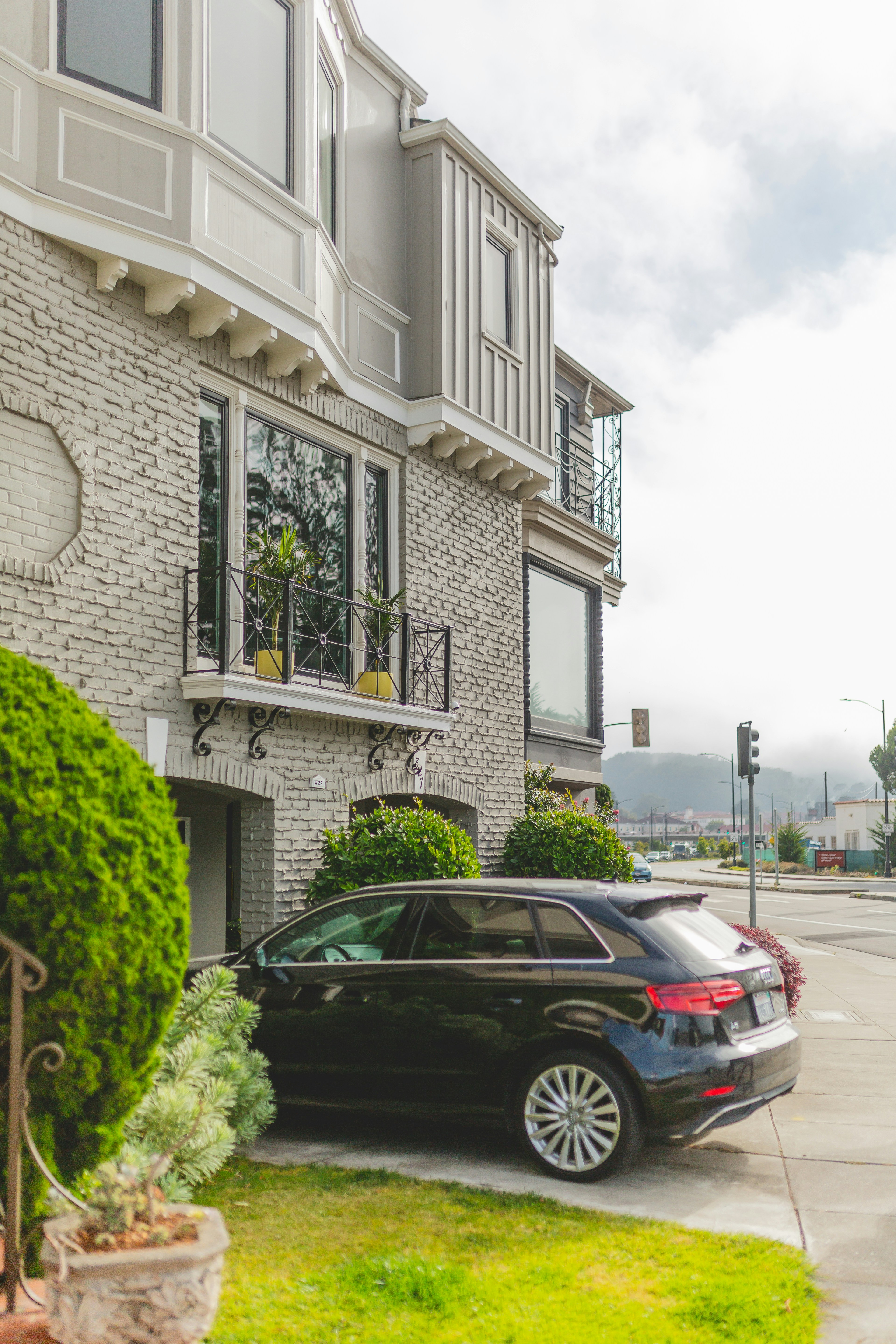 Balconies, Brick, and a Black SUV: A Quiet Street Portrait