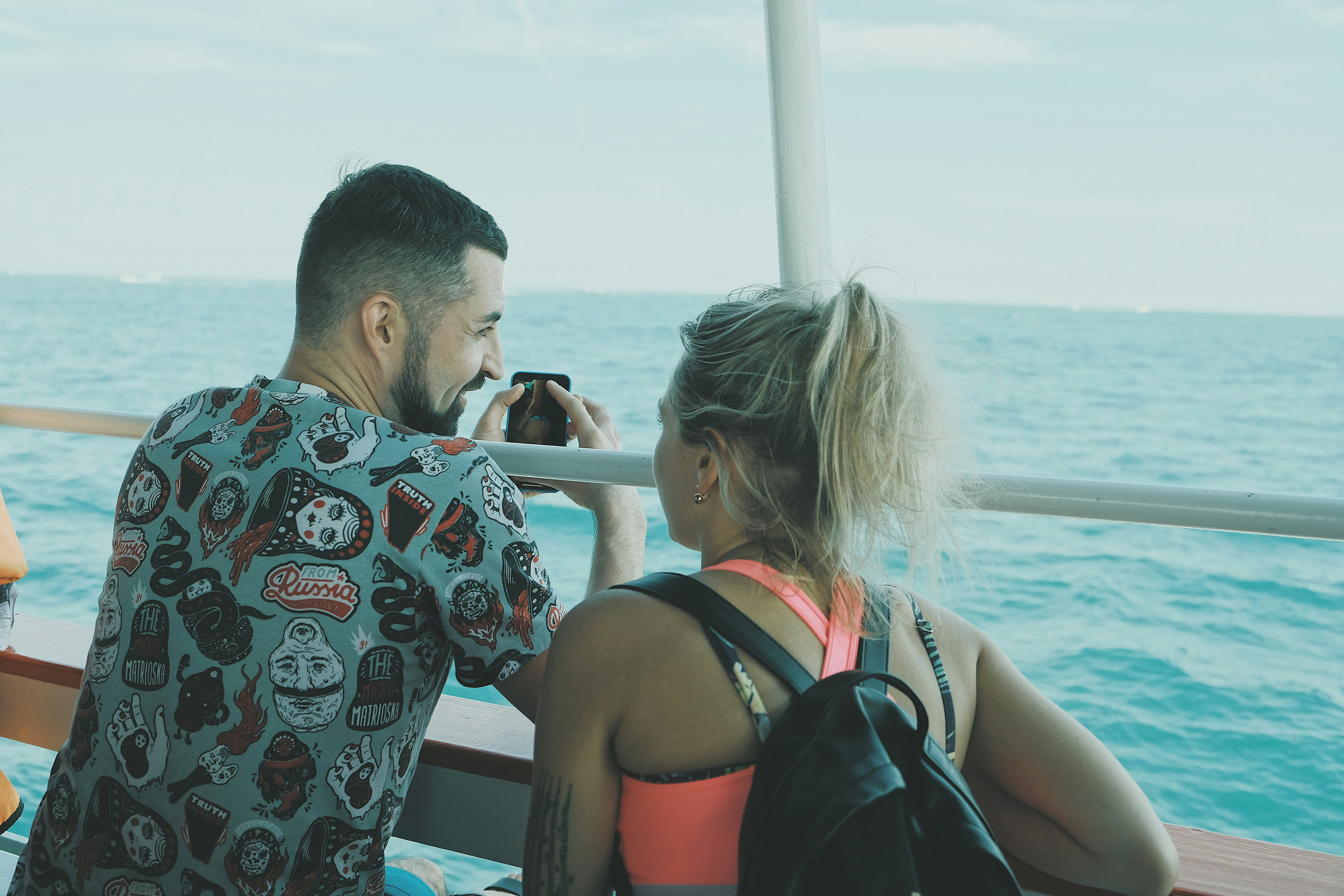 a man taking a picture of a woman on a boat