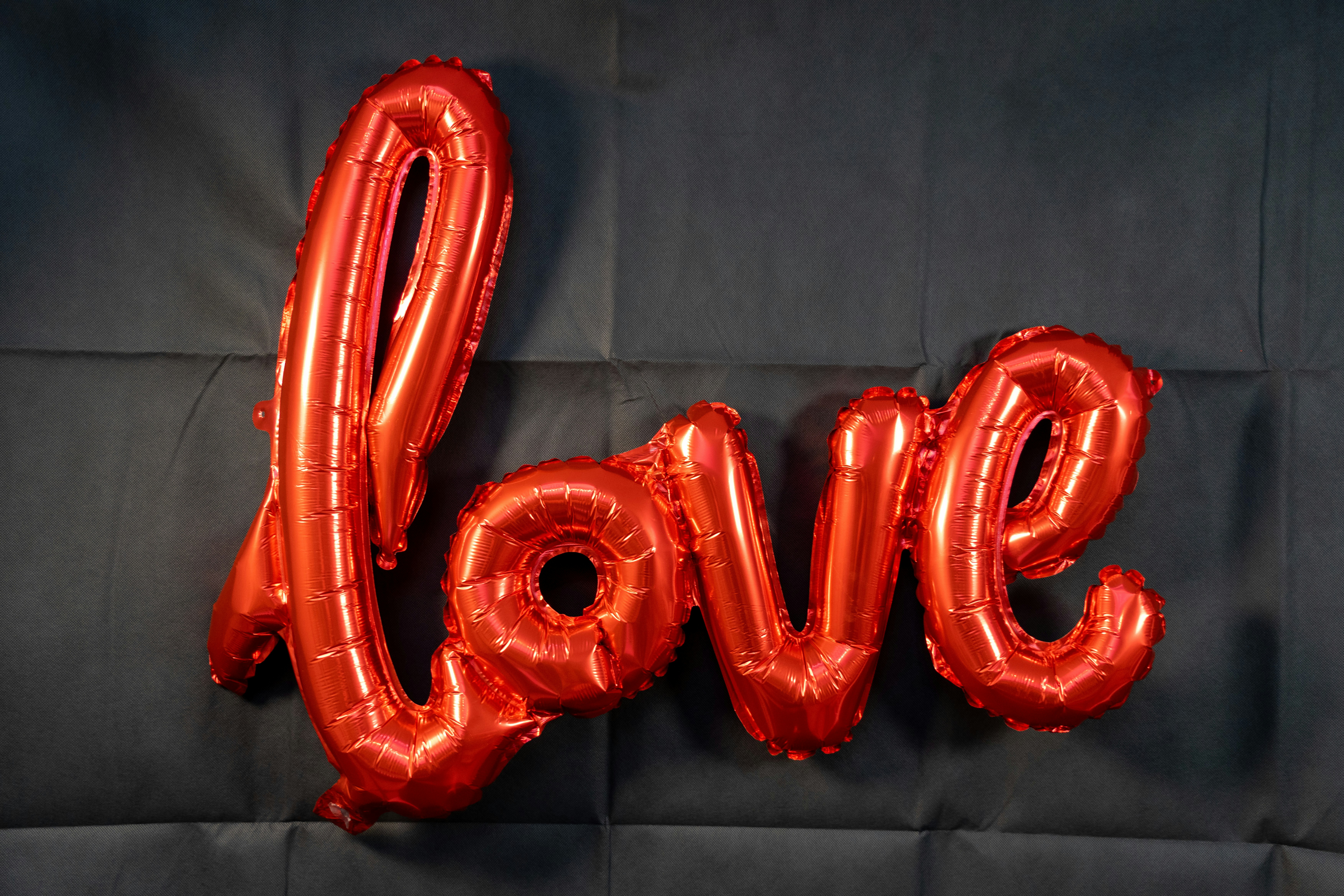 A red balloon spelling love on a black background photo – Free Image on ...