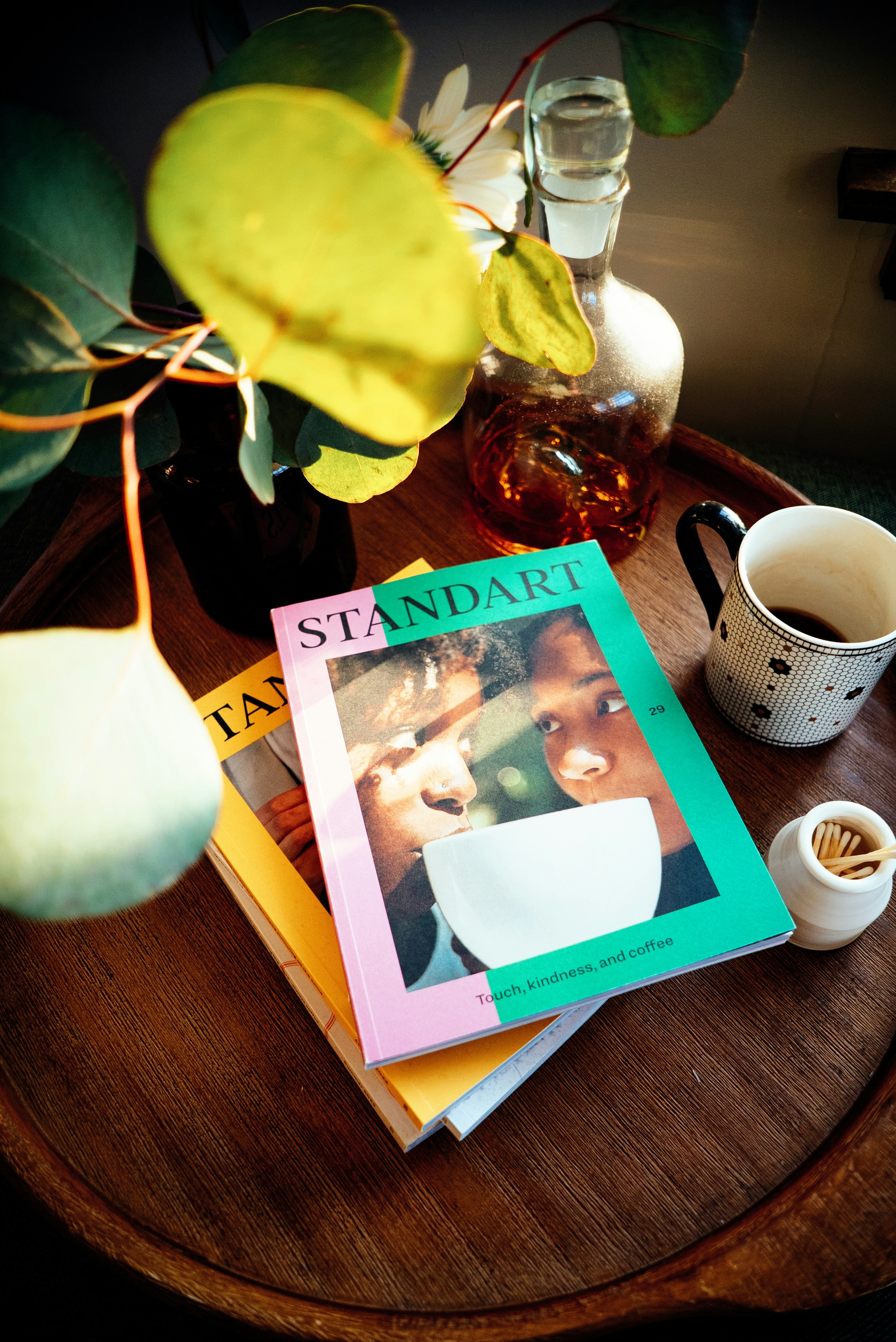 a wooden table topped with books and a cup of coffee