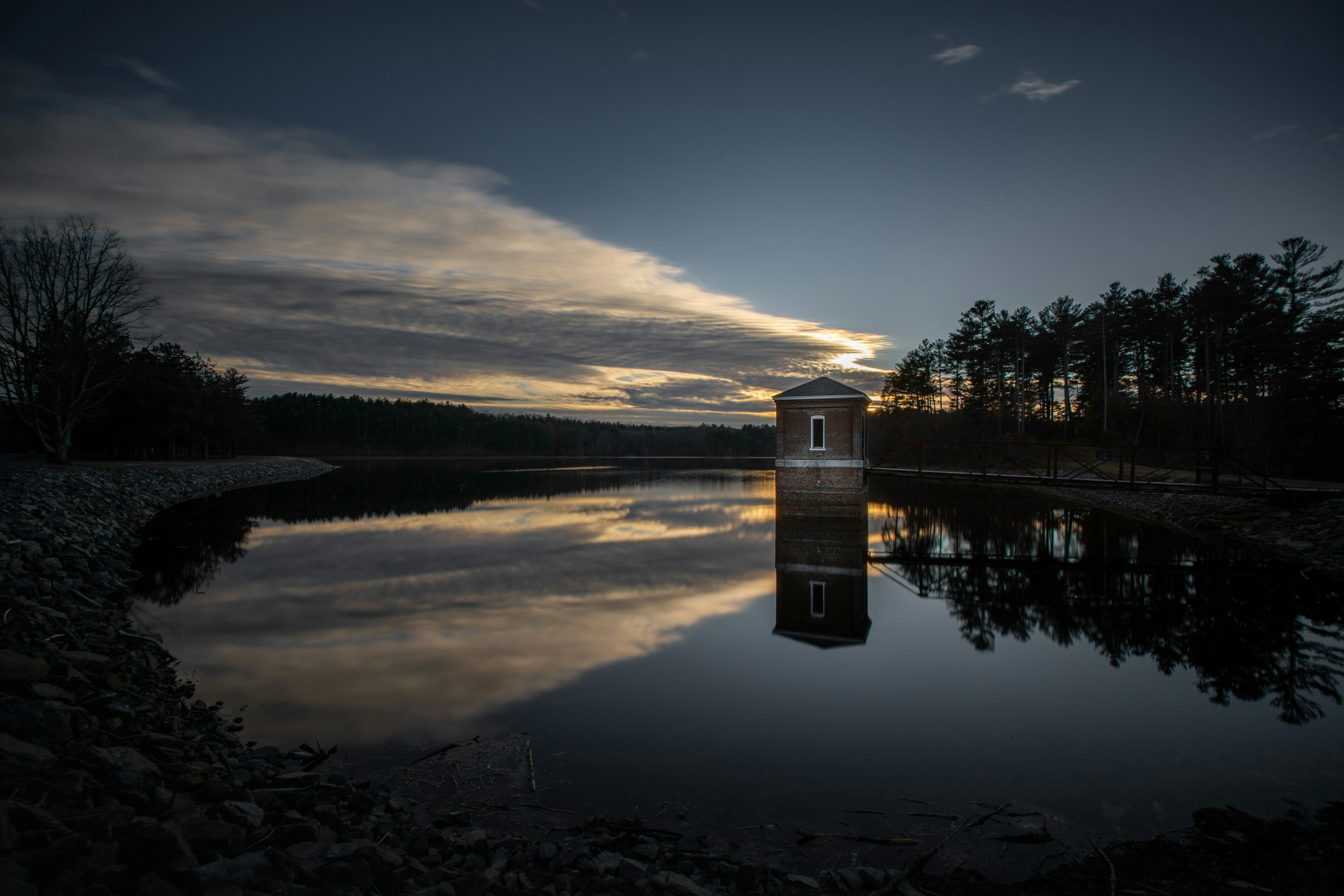 Moonlit Reflection: A Brick Watchtower on a Glassy Lake