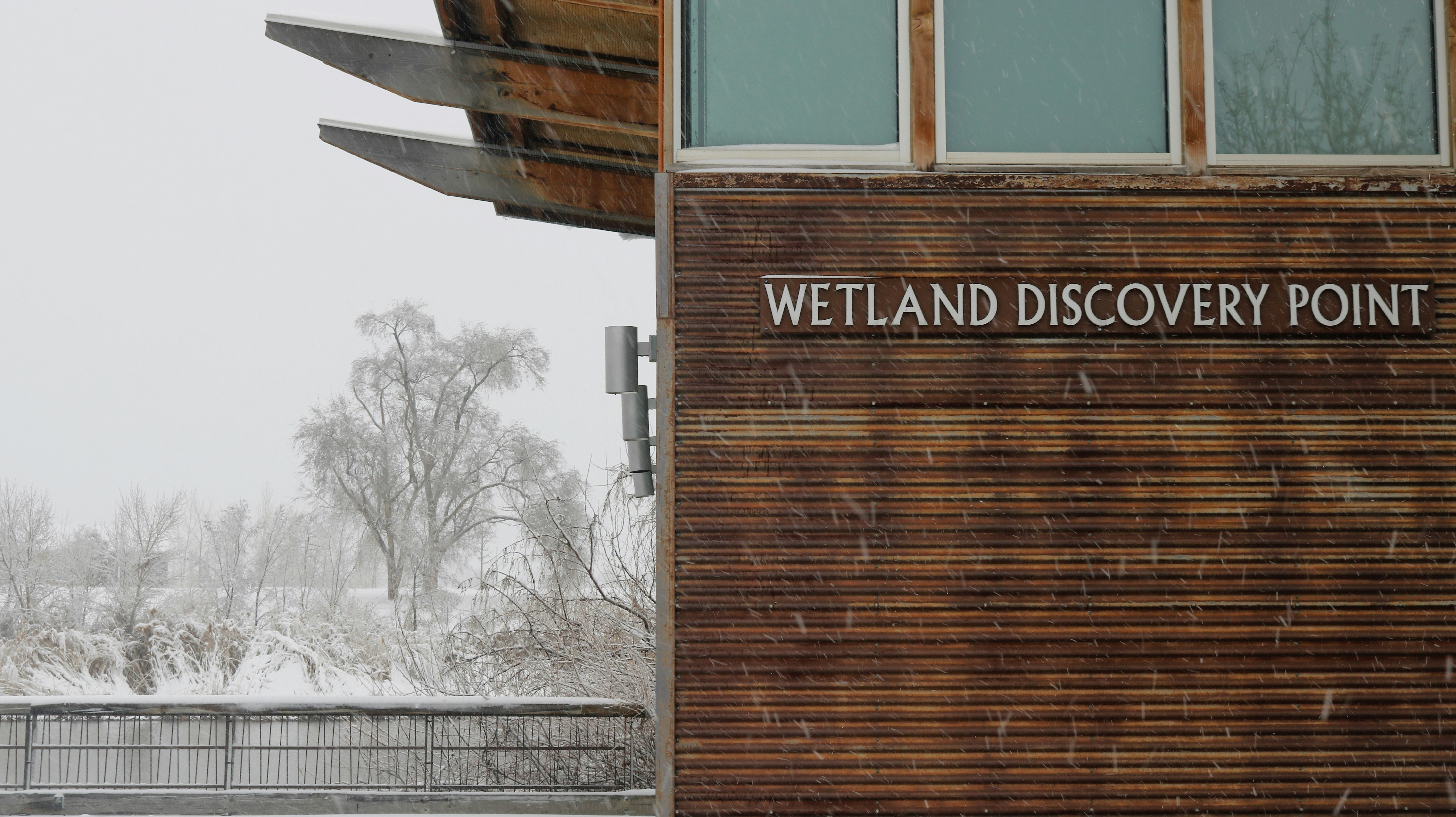 a wooden building with a sign that says wetland discovery point