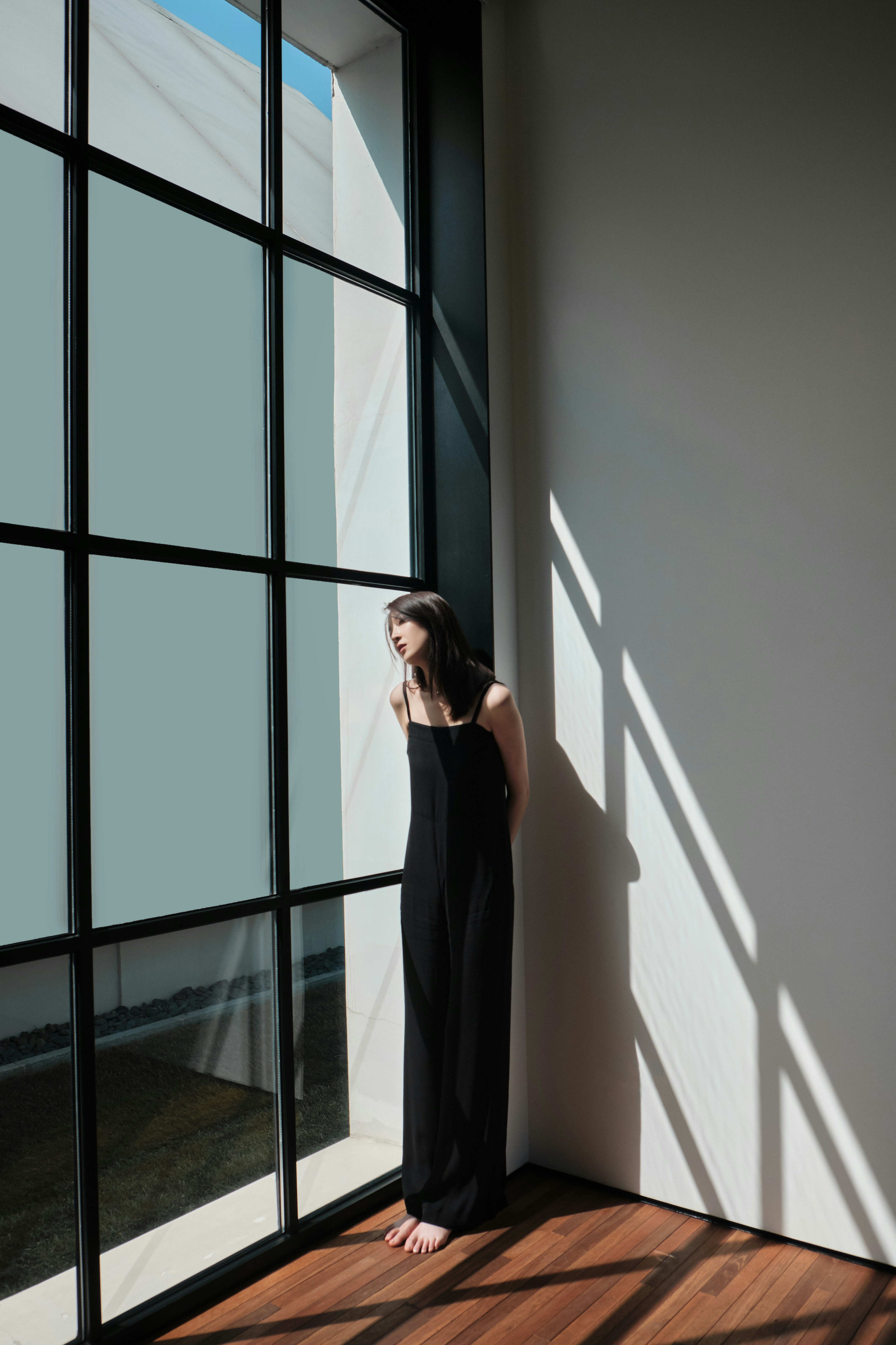 A woman leaning against a wall next to a window photo – Free People ...