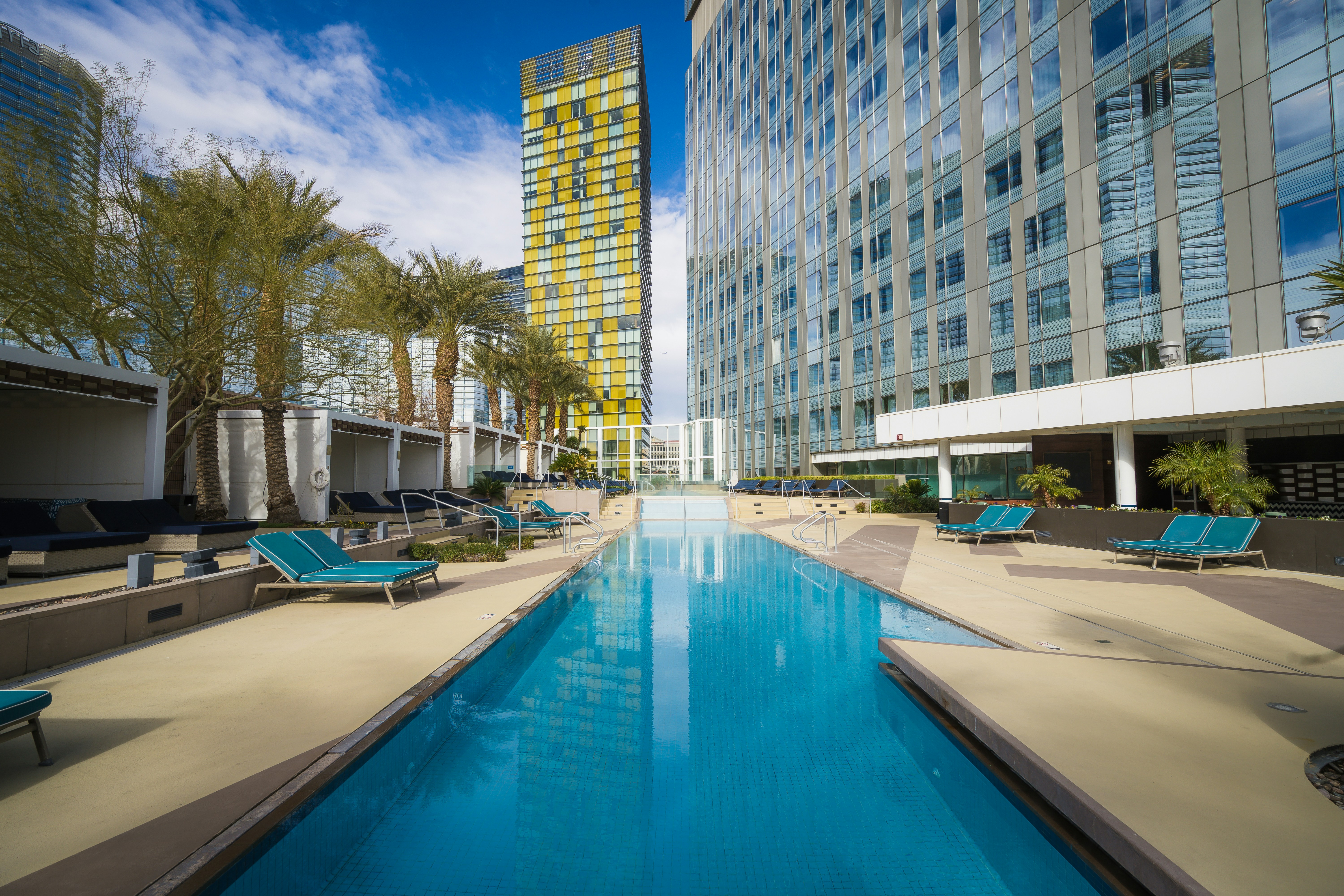 A long swimming pool in front of a tall building photo – Free Hotel ...