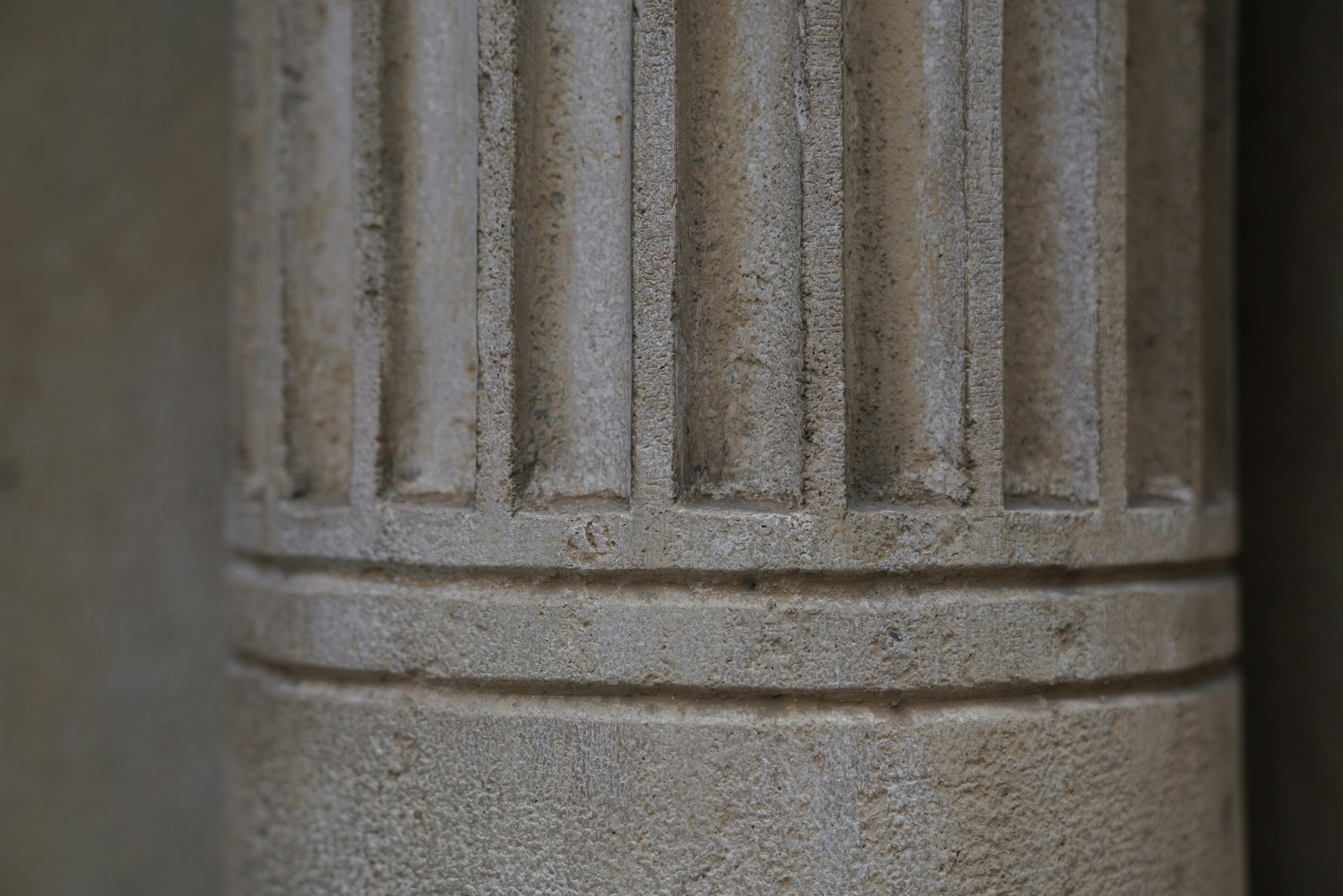 a close up of a stone column with a clock on it