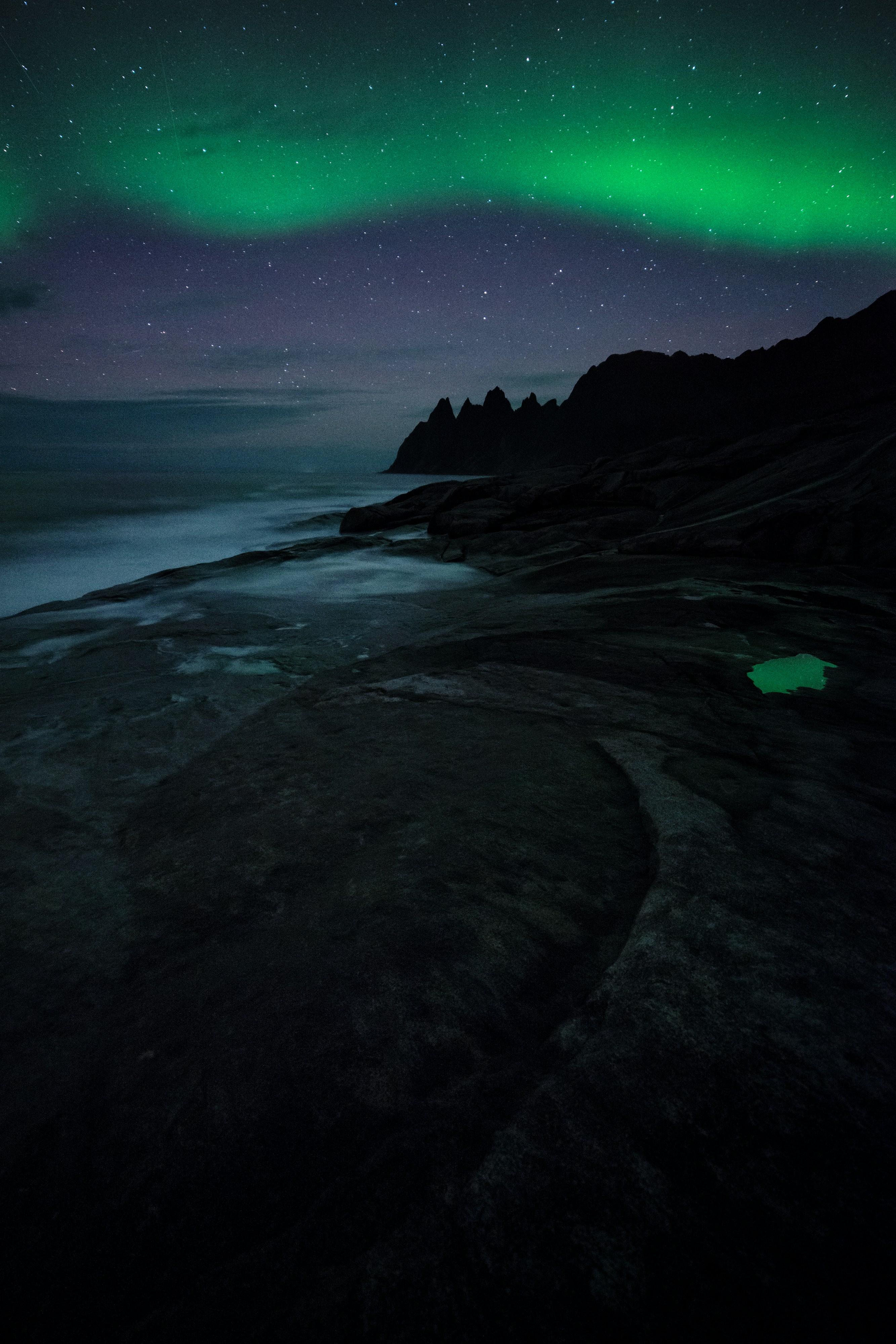 A green and black aurora over a body of water photo – Free Tungeneset ...