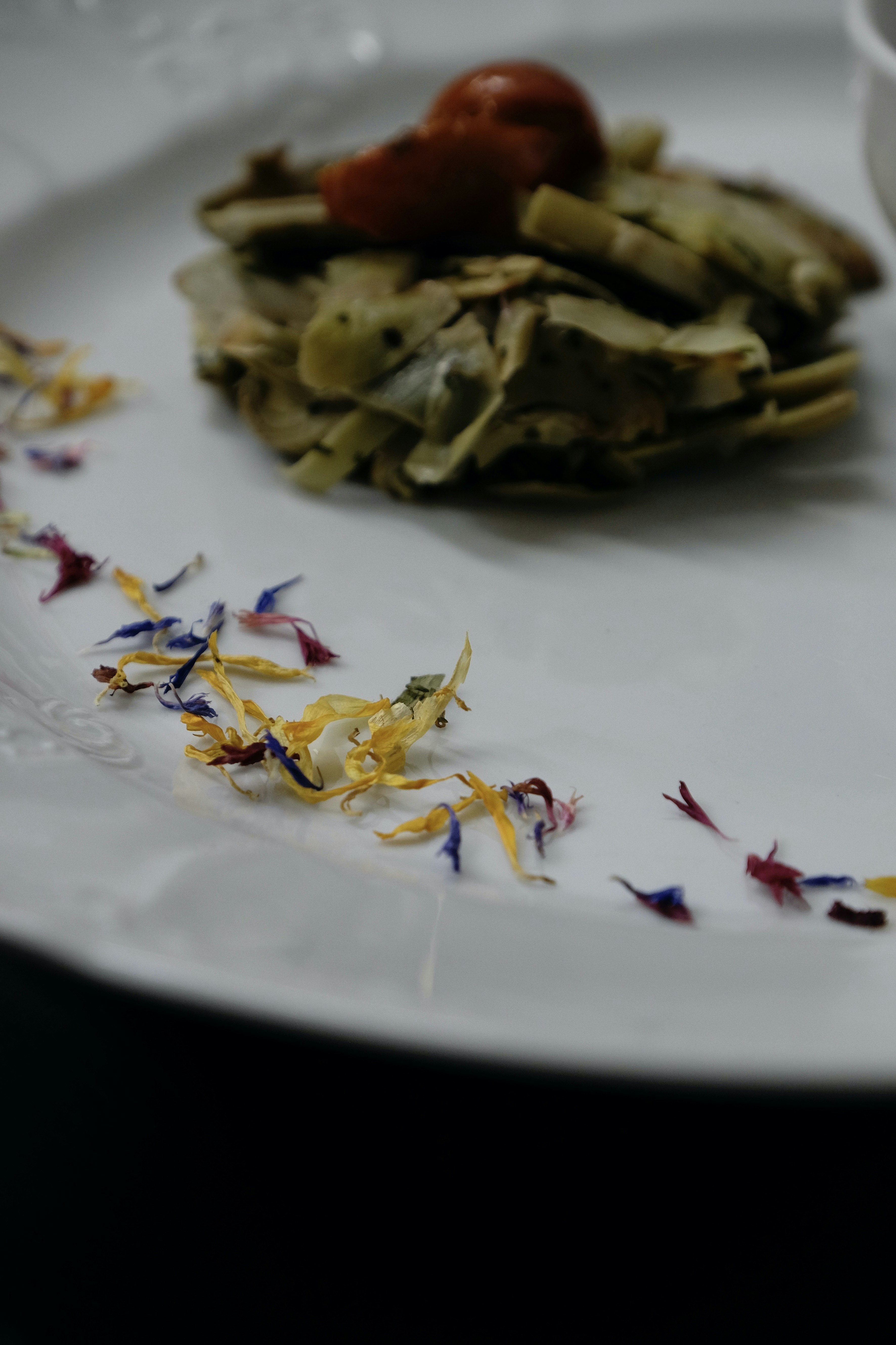 Petal Confetti on a White Plate, with a Soft-Focus Pasta Nest in the Background