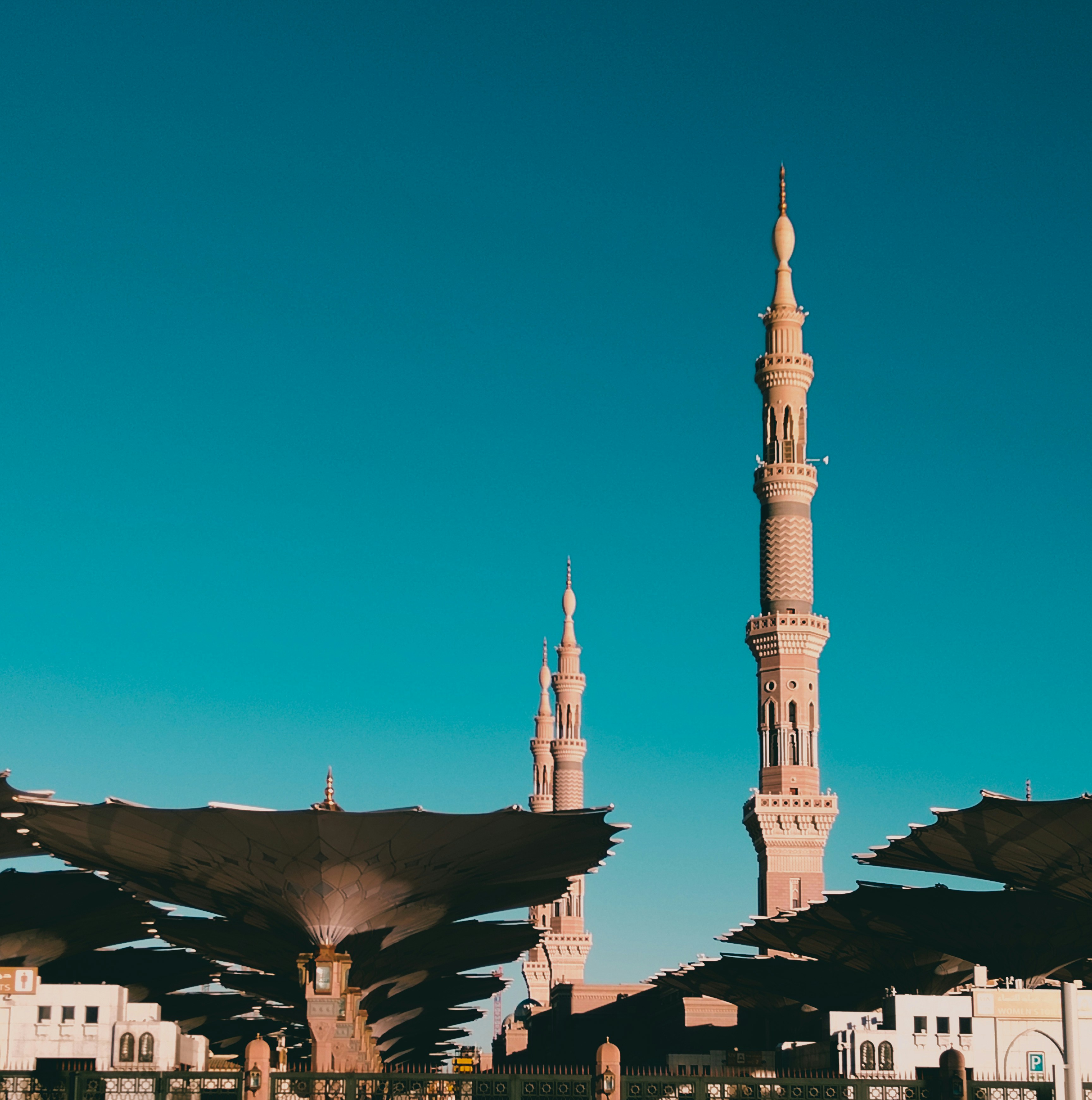 A tall building with a clock tower in the background photo – Free ...