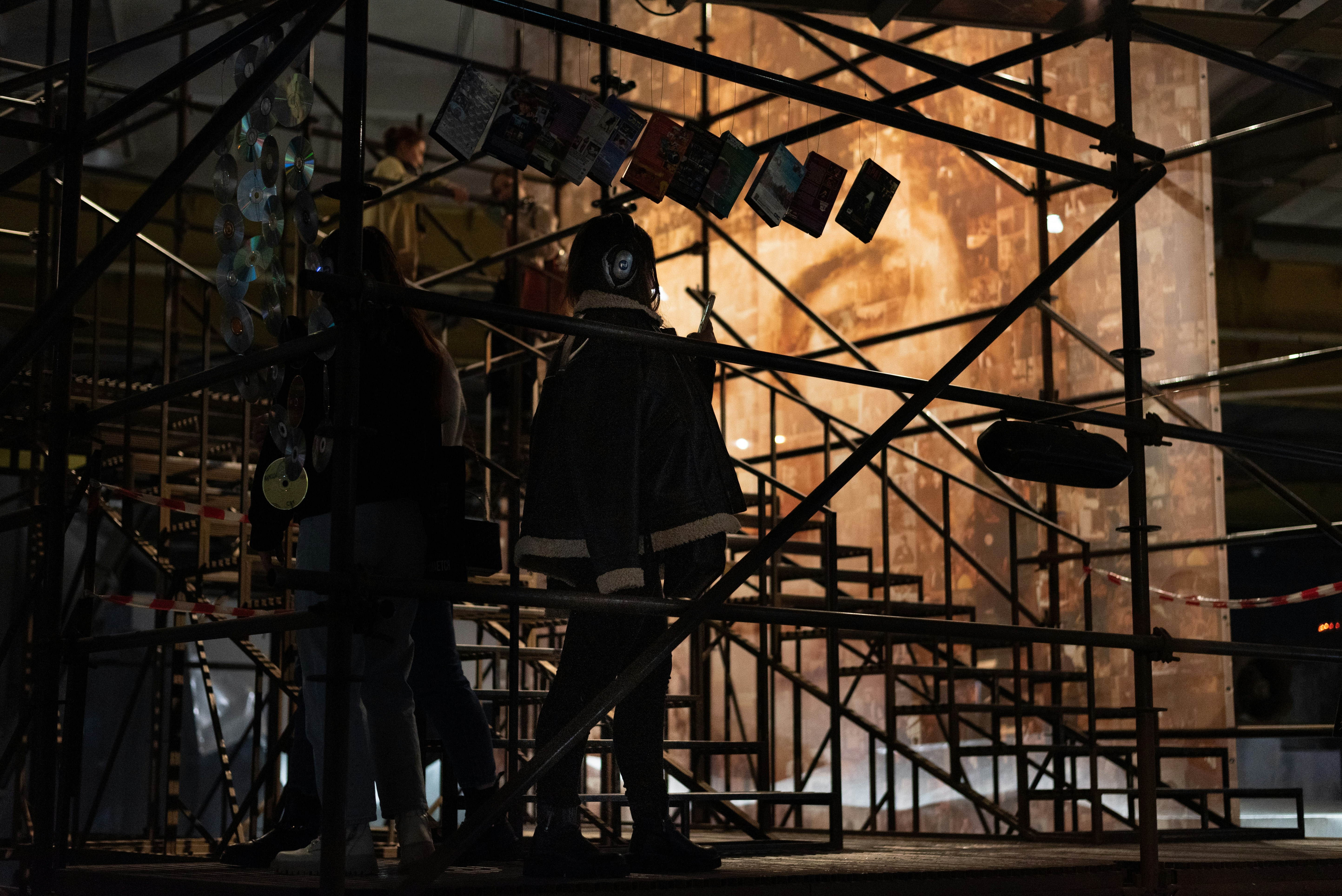 Pyro-Backstage: Silhouettes Within Scaffolding Beneath a Firelit Backdrop