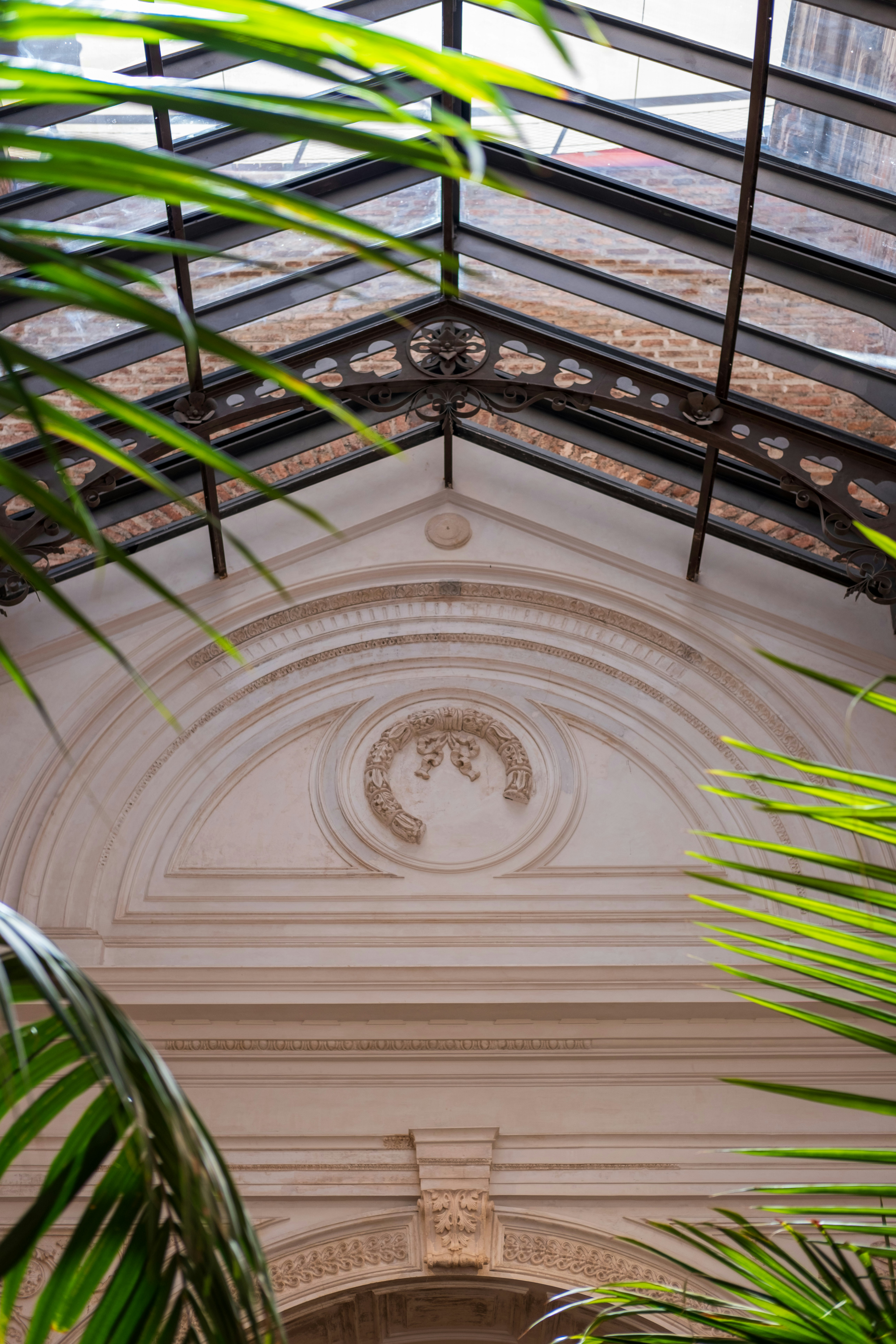 Ornate Archway Framed by Tropical Foliage Under Glass