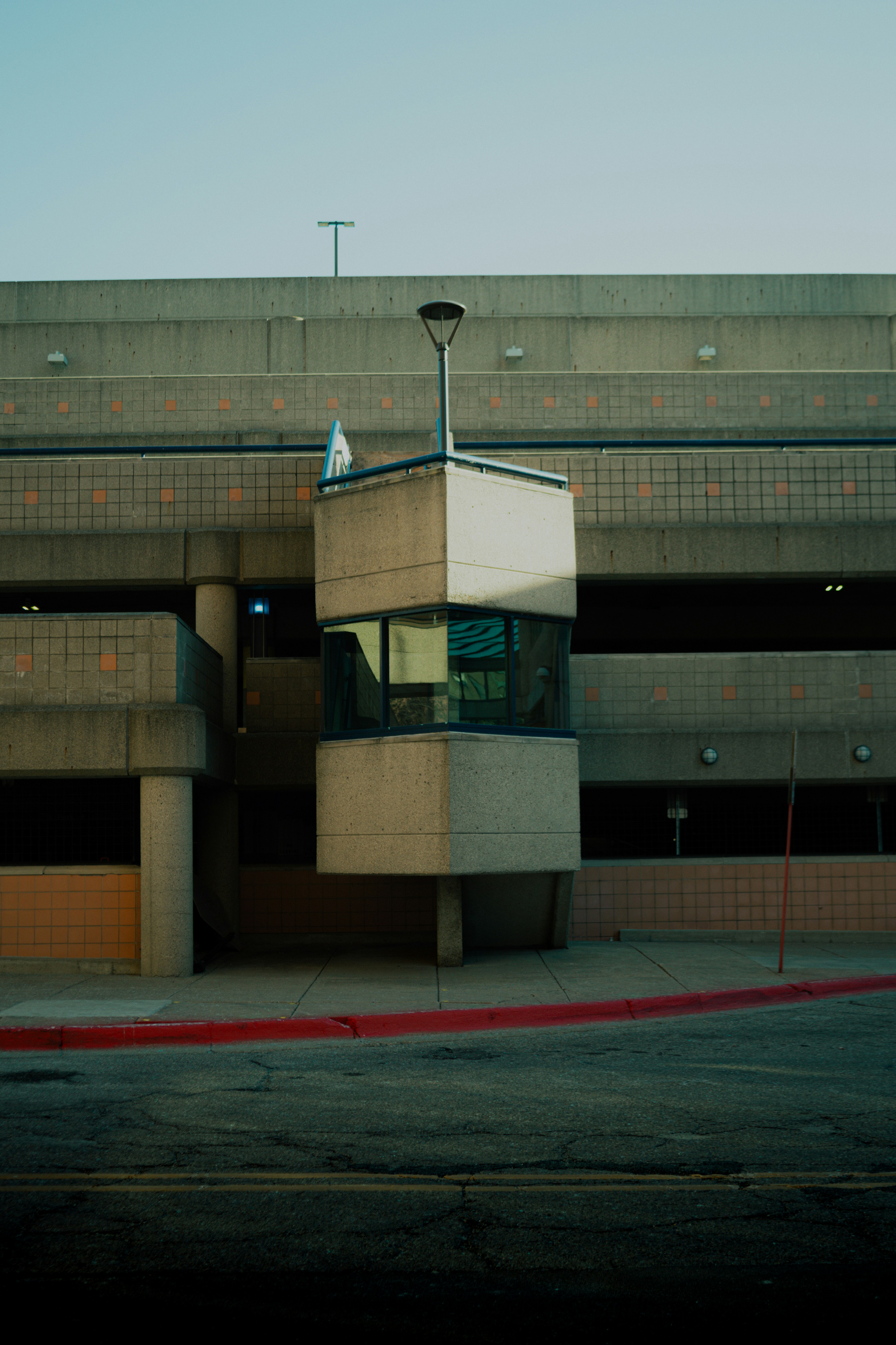 Brutalist Glass Booth: Still Centered Within Concrete Ramps
