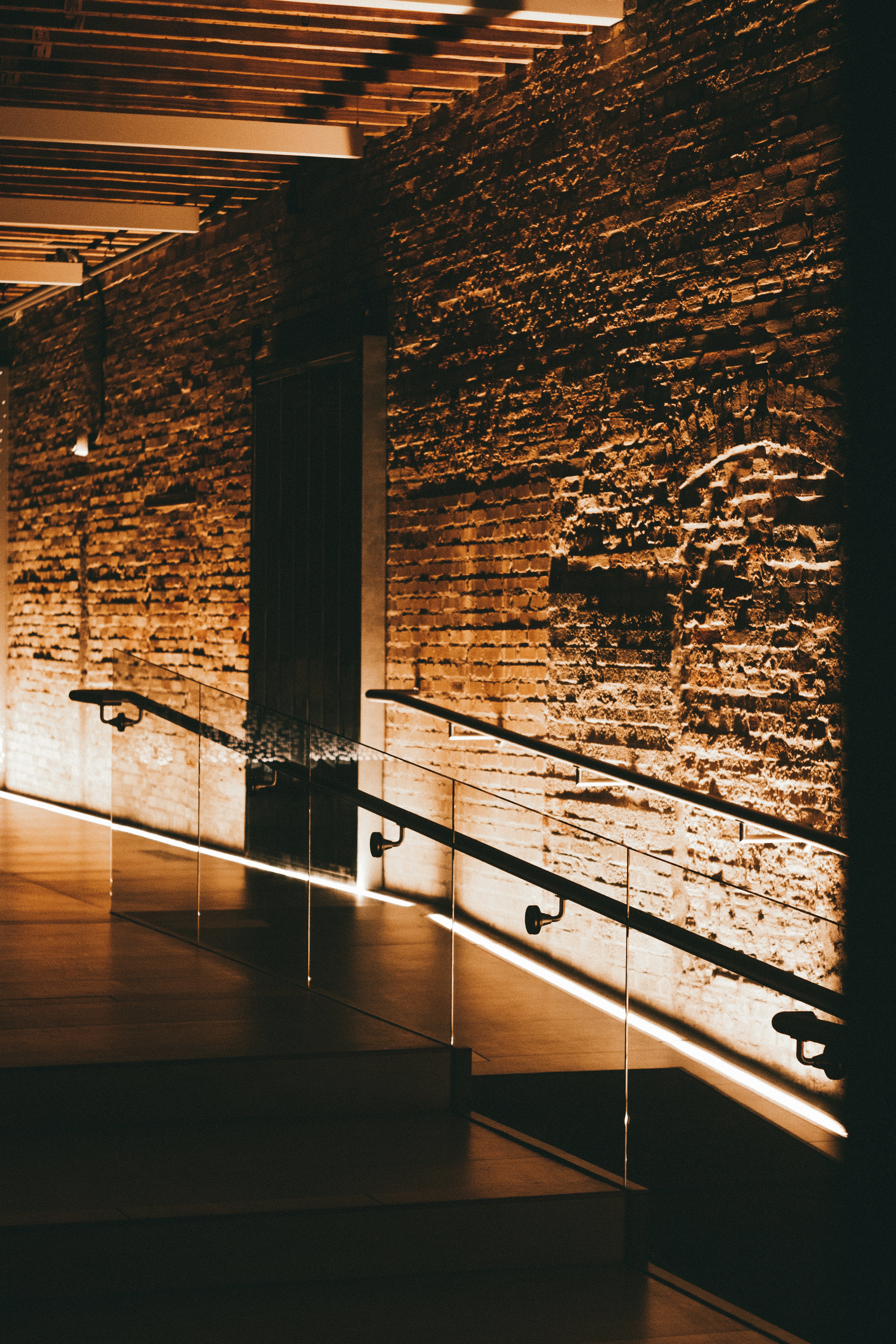 Ember Corridor: Brick Wall, Glass Rail, and Quiet Glow