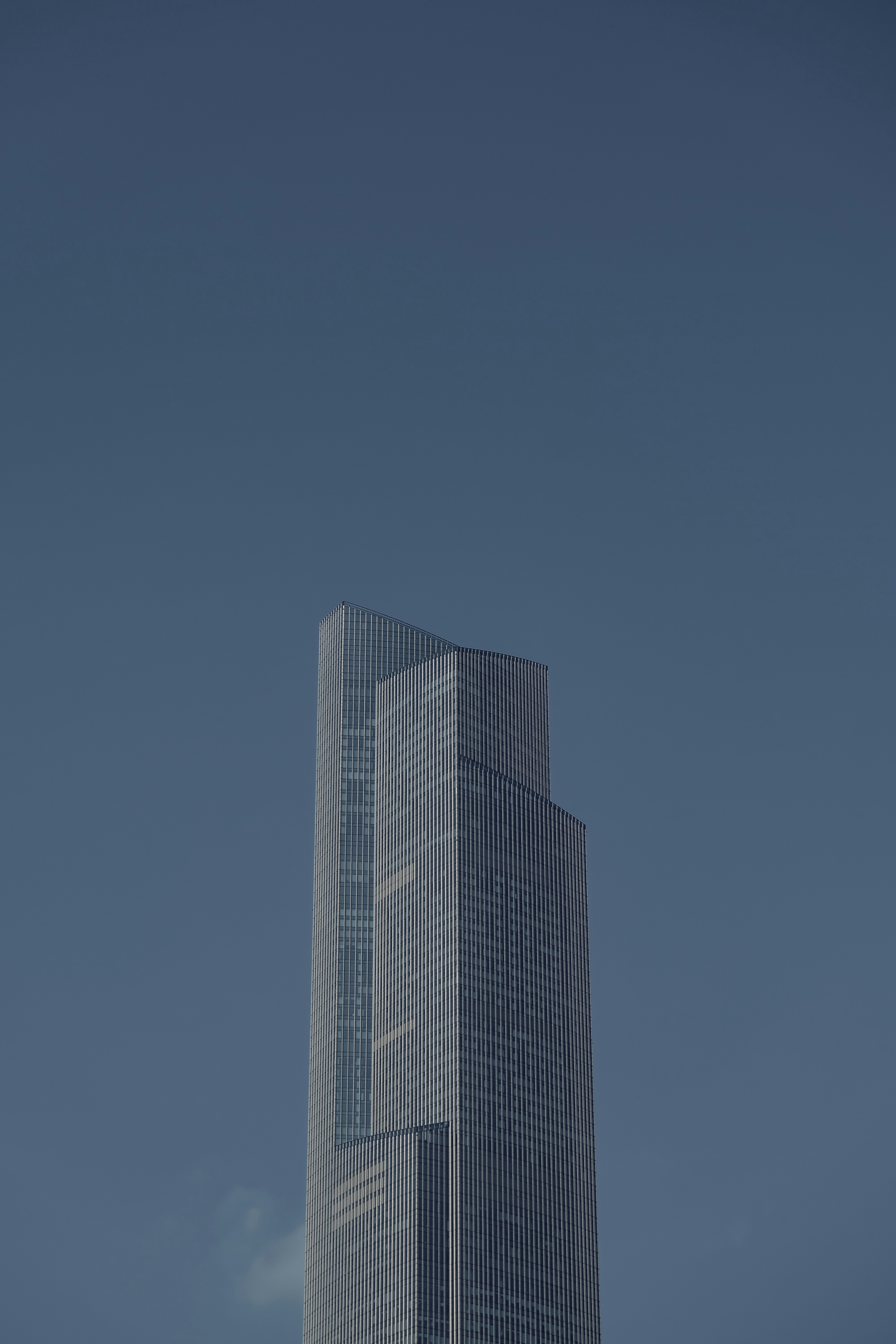 A tall building with a plane flying in the sky photo – Free Guangzhou ...
