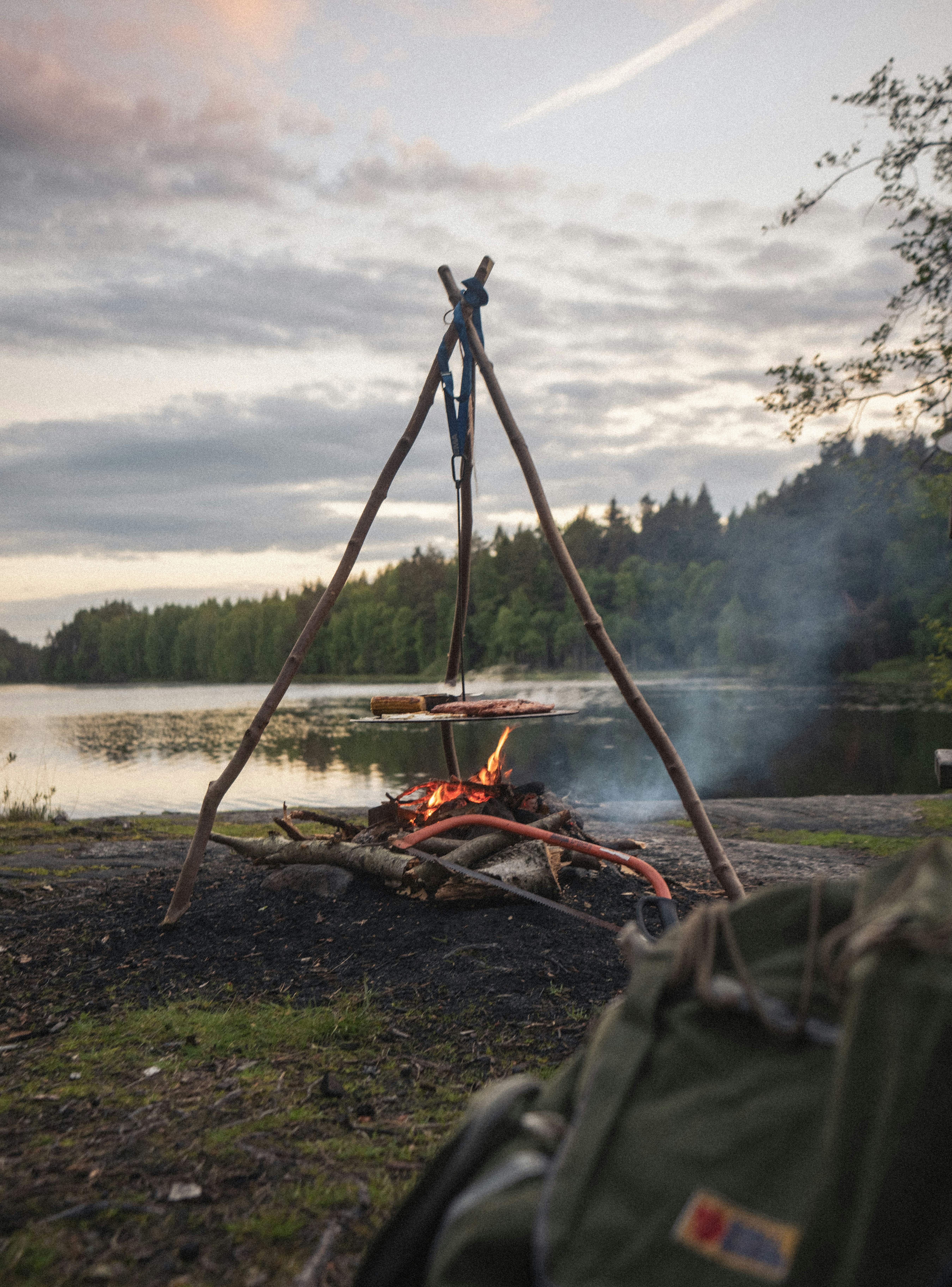 A campfire in a field next to a lake photo – Free Fire Image on Unsplash