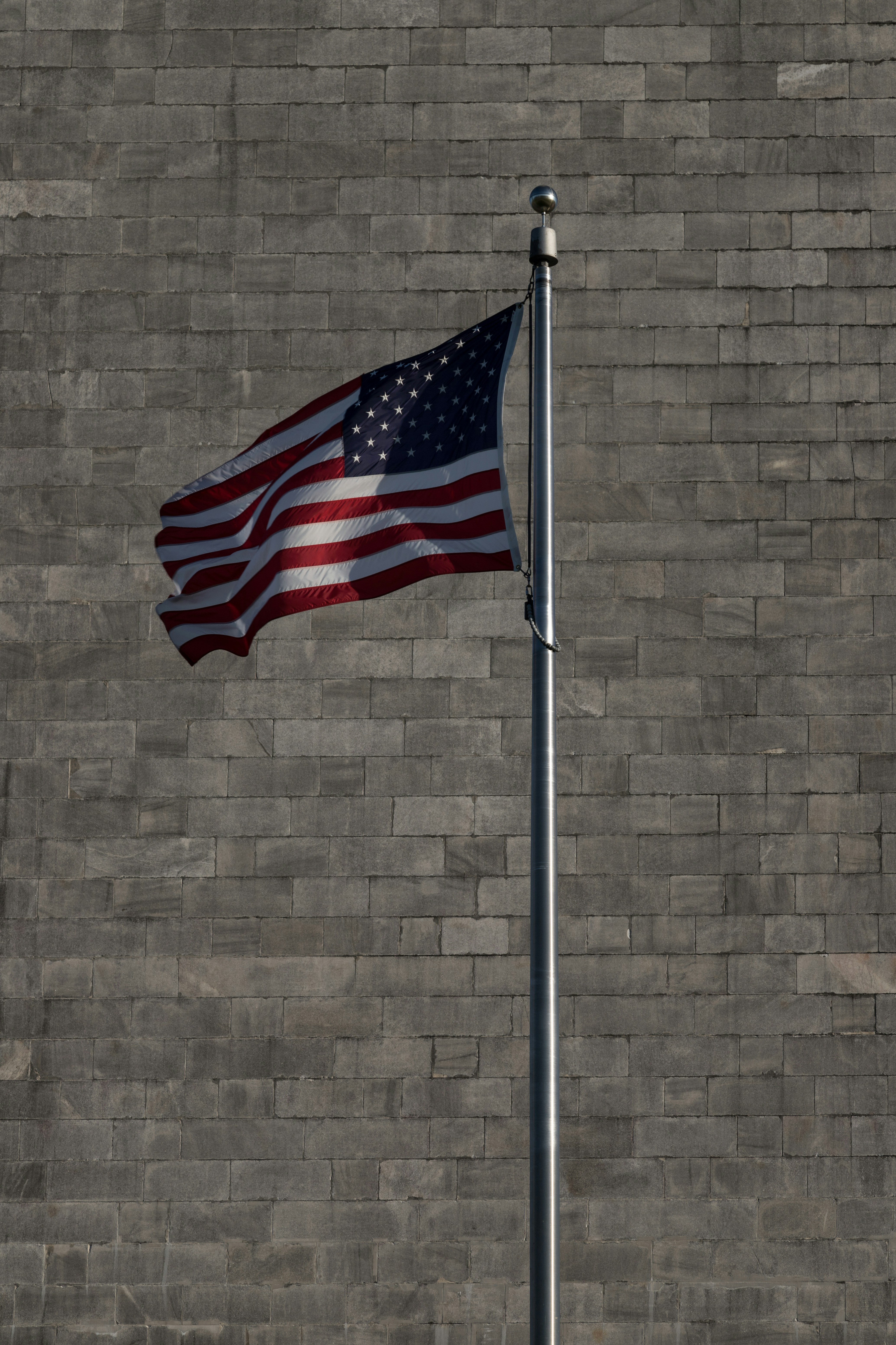 Flag against a weathered wall: a quiet portrait of motion