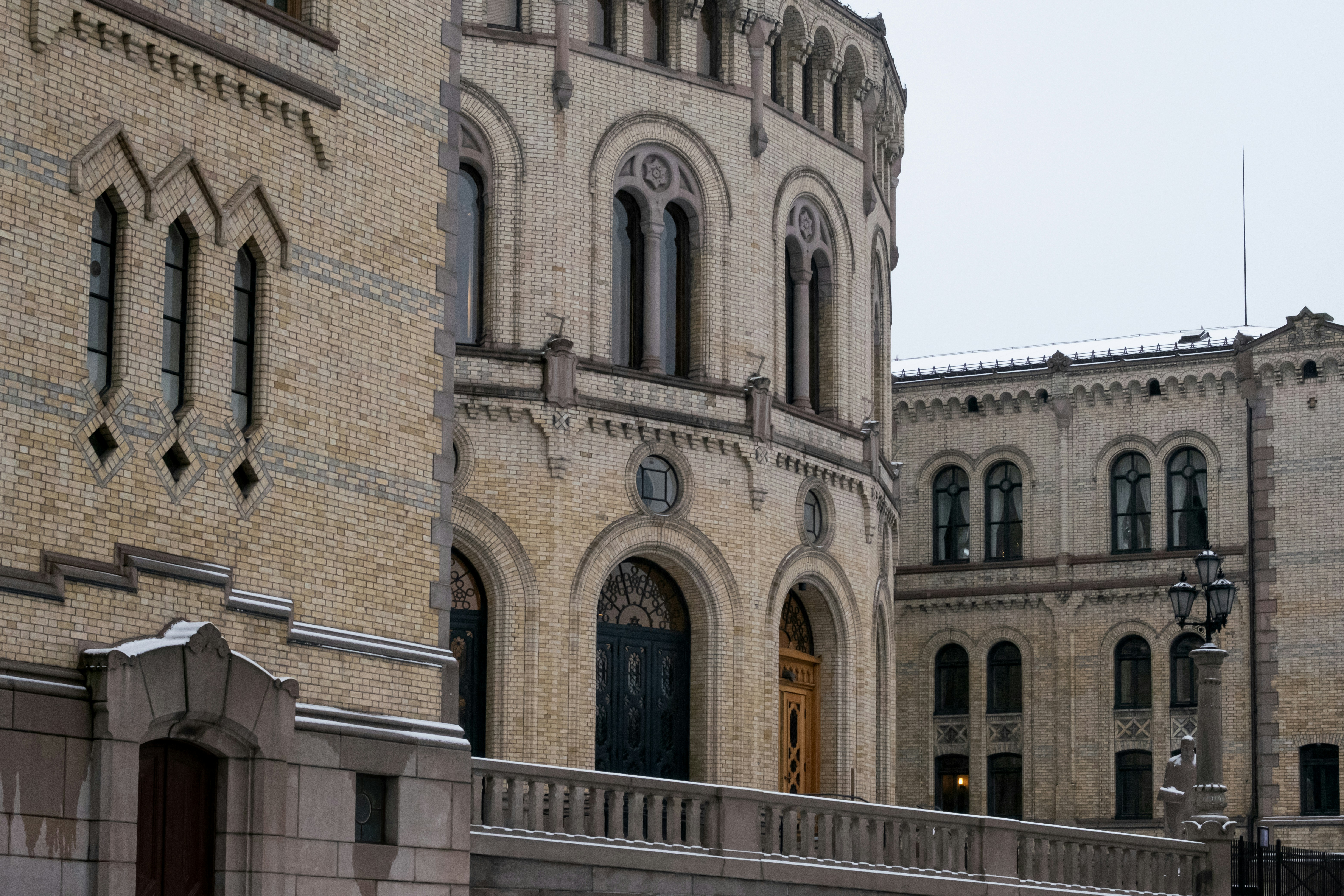 Ornate stone building with arched windows and intricate detailing, featuring a prominent clock.
