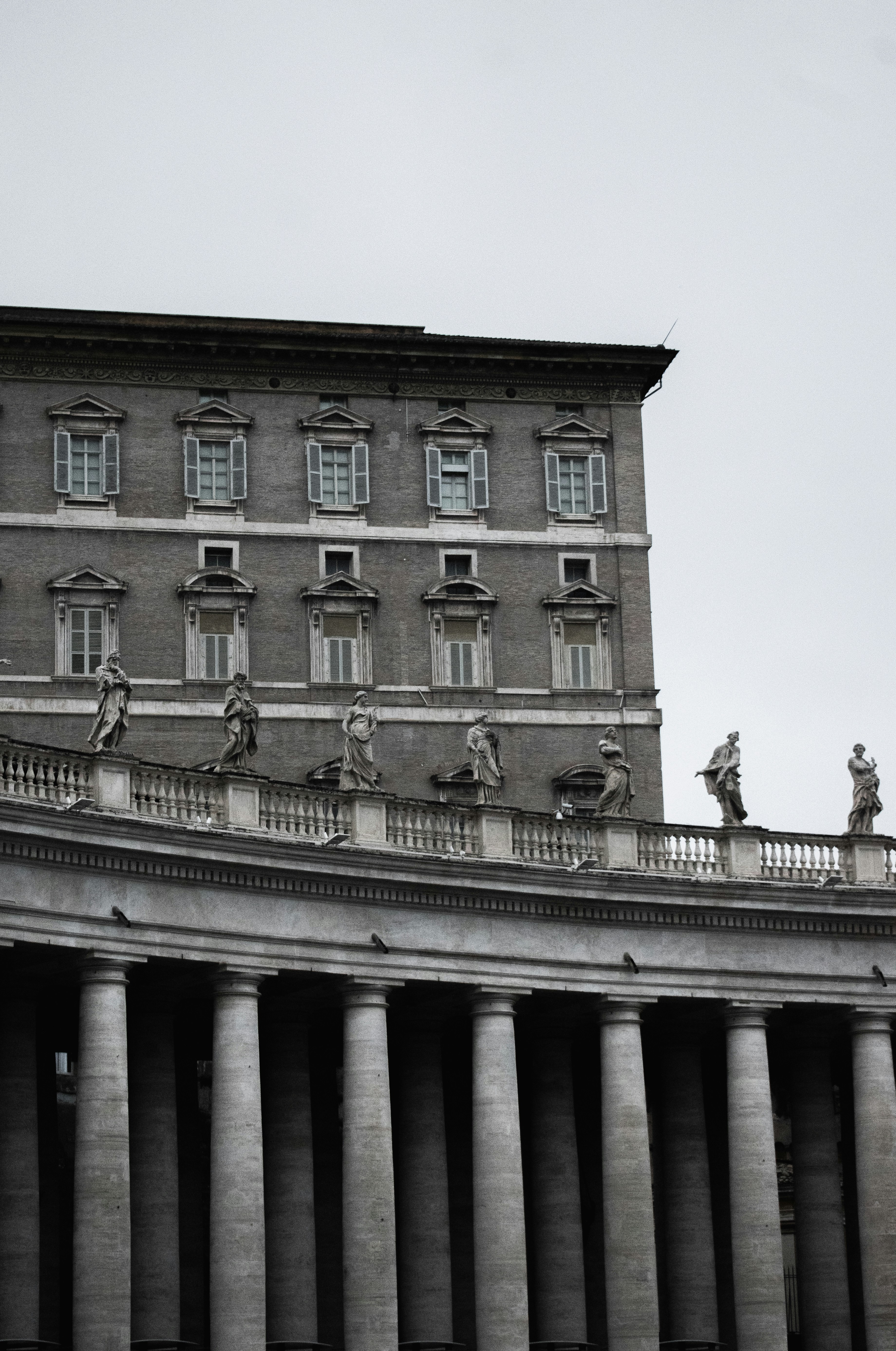 A very tall building with columns and statues on top of it photo – Free ...
