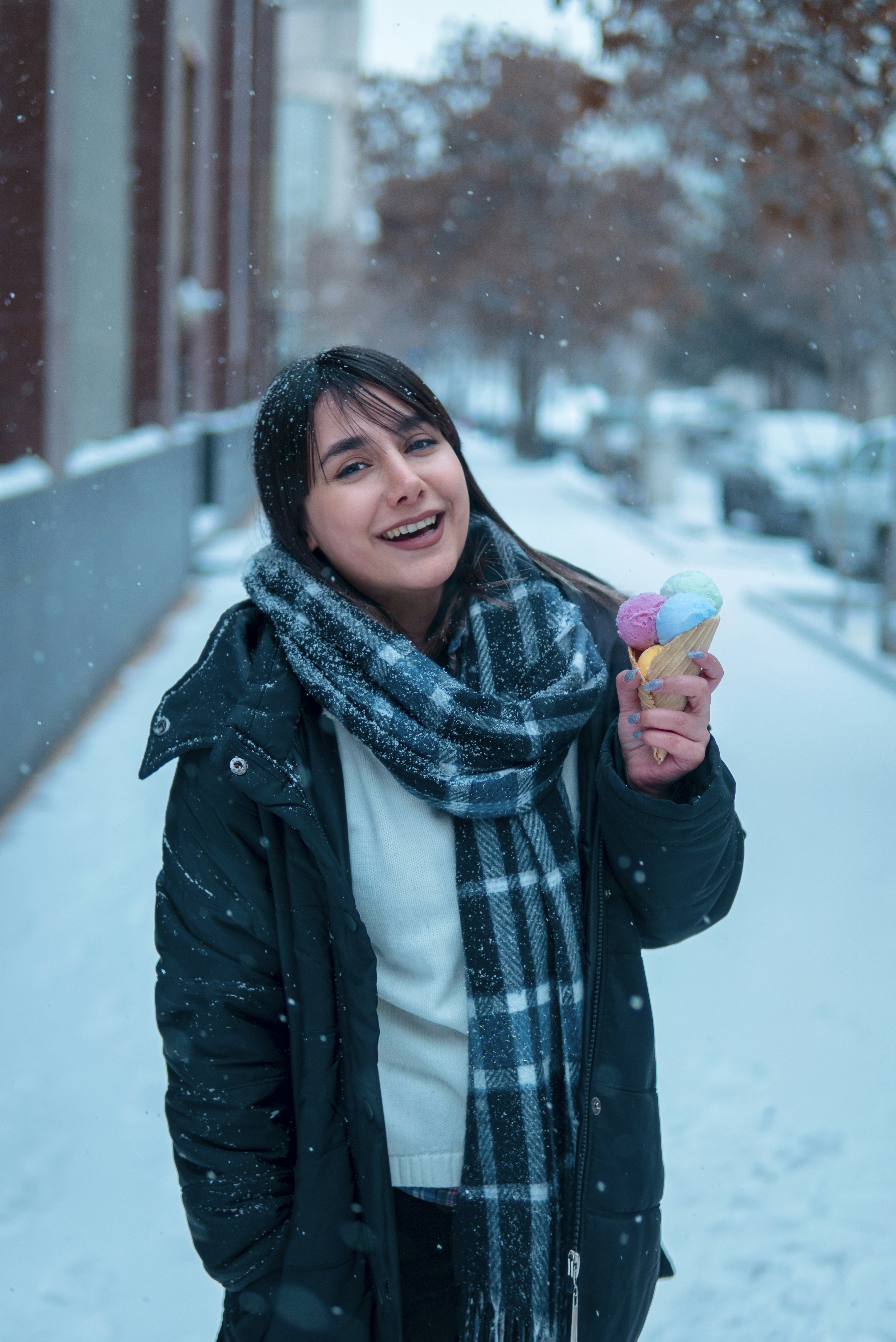 a woman holding an ice cream cone in the snow