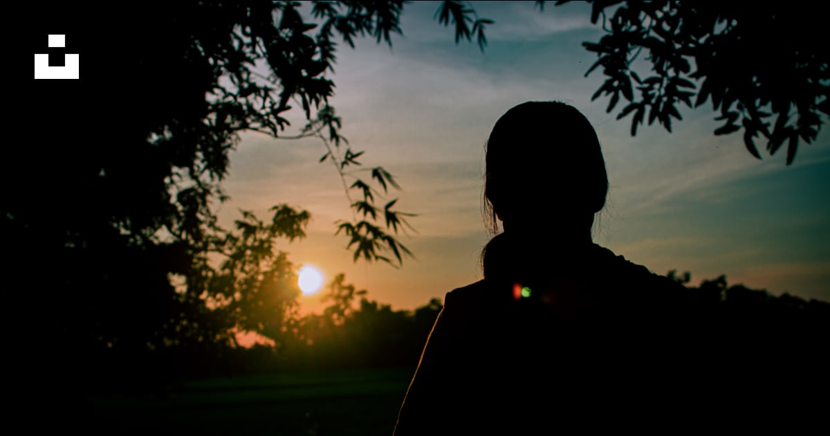 Una Persona Parada Debajo De Un árbol Al Atardecer Foto Imagen De