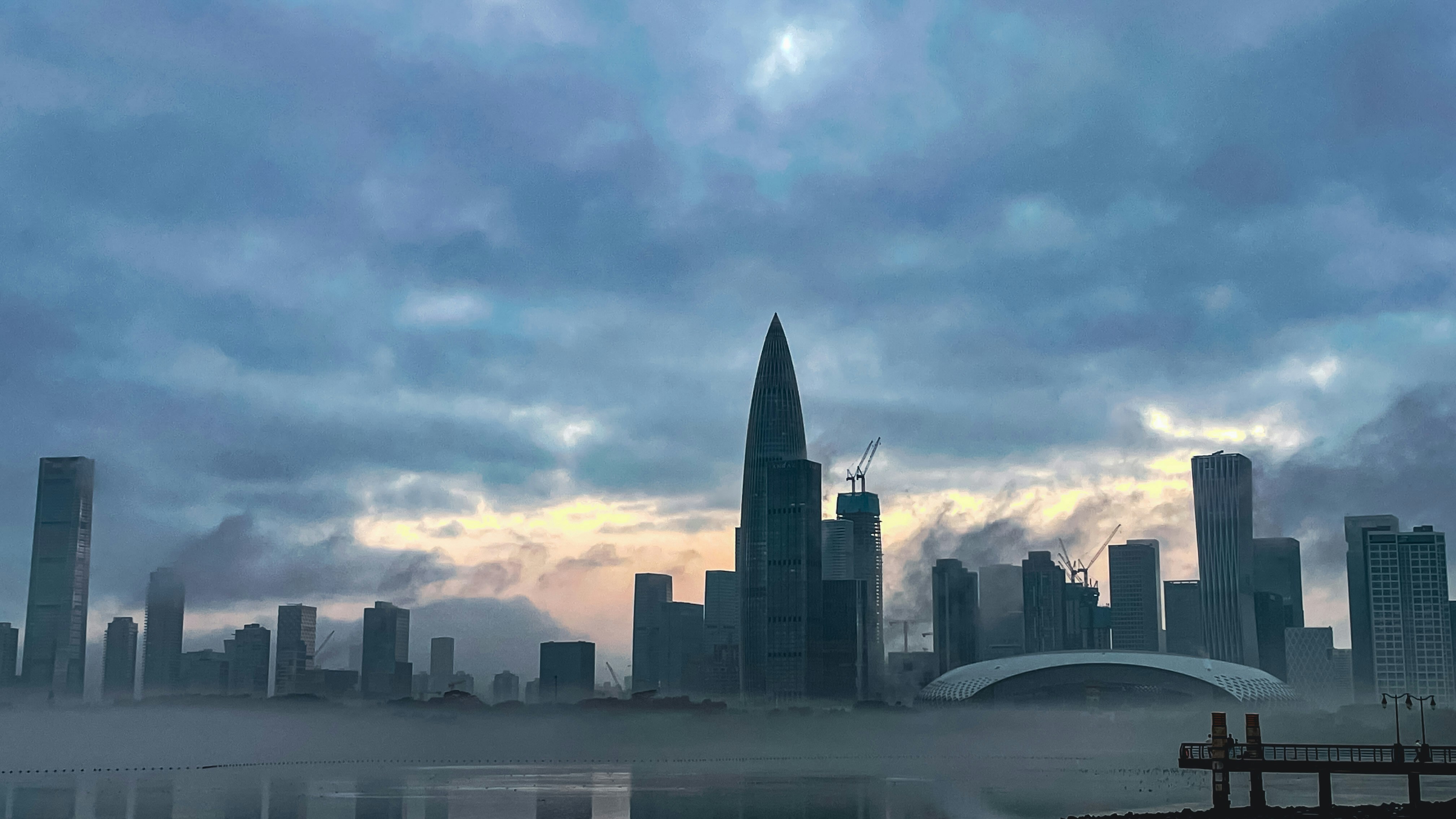 Silhouetted Skyline at Dusk: A Calm Harbor of Giants
