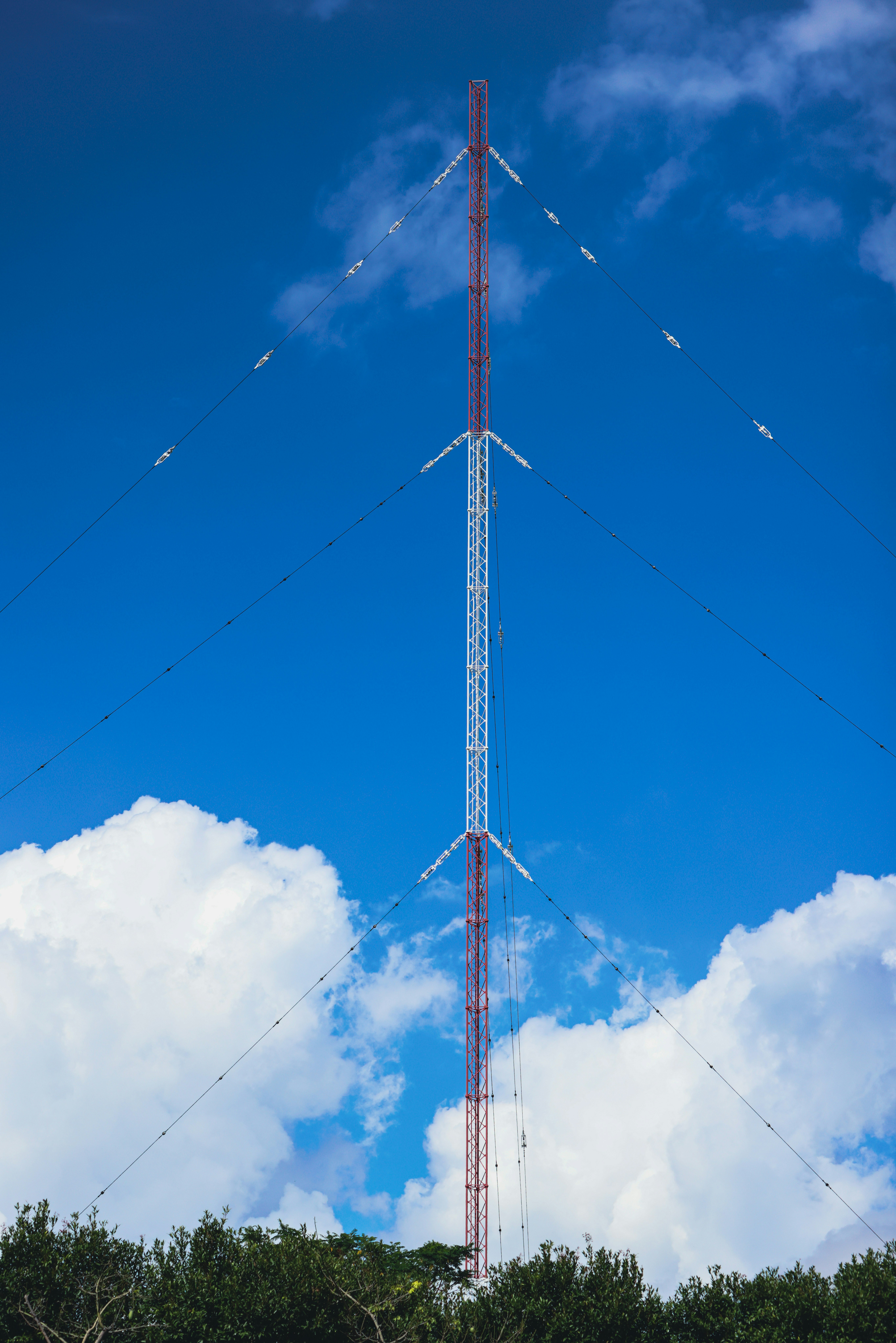 Skyward Signal: A Crimson Mast Rises Through Cerulean Sky